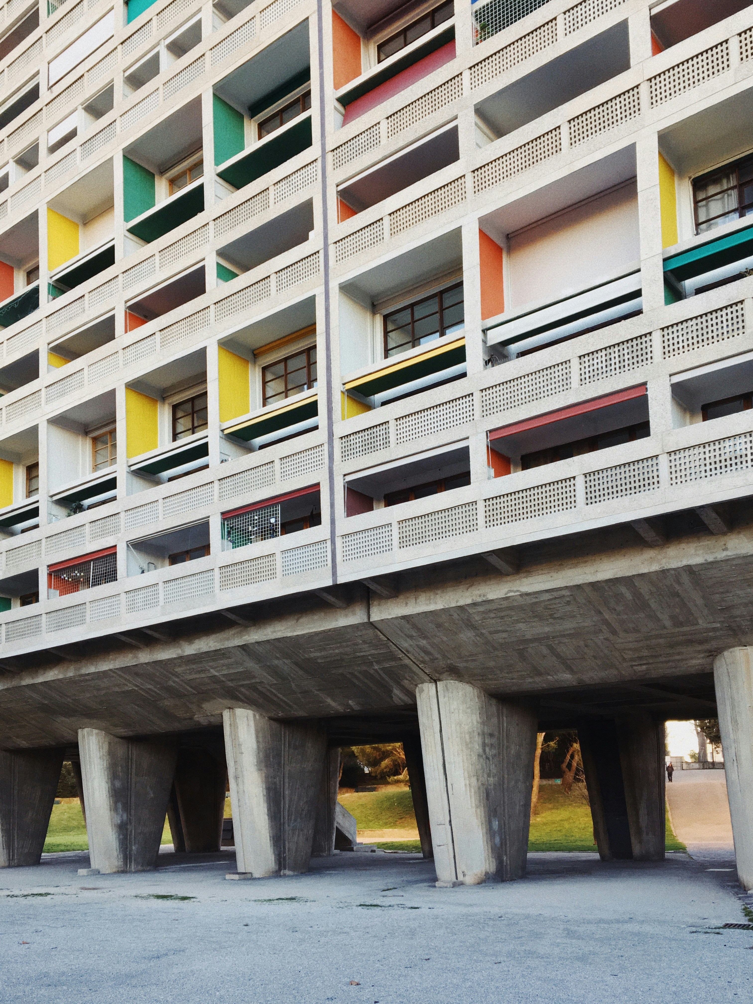 Colorful apartment building with a unique concrete structure, showcasing vibrant window frames and a distinct modernist design.