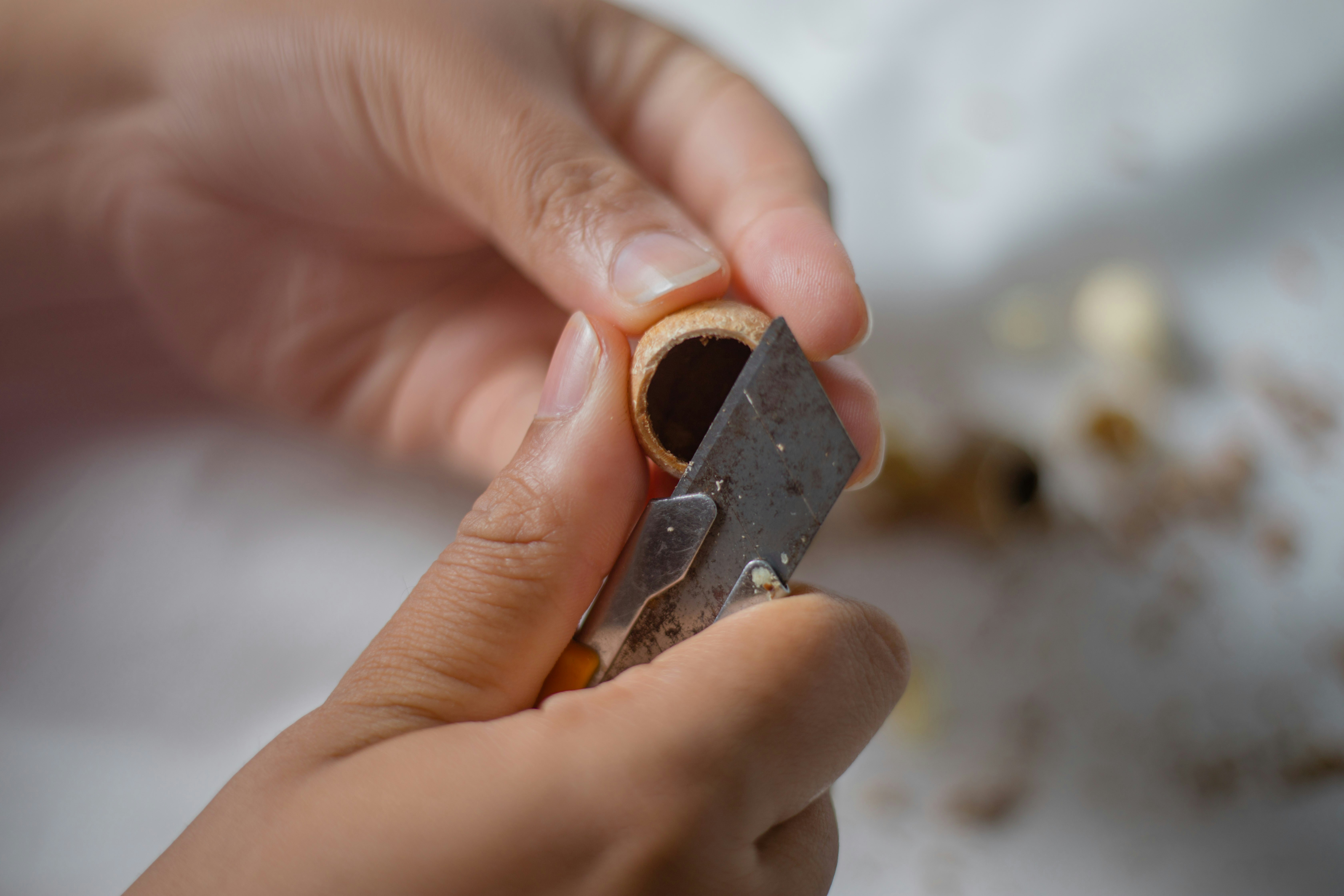 Close-Up Hands Examine a Tiny Hollow Metal Tube with Copper Interior