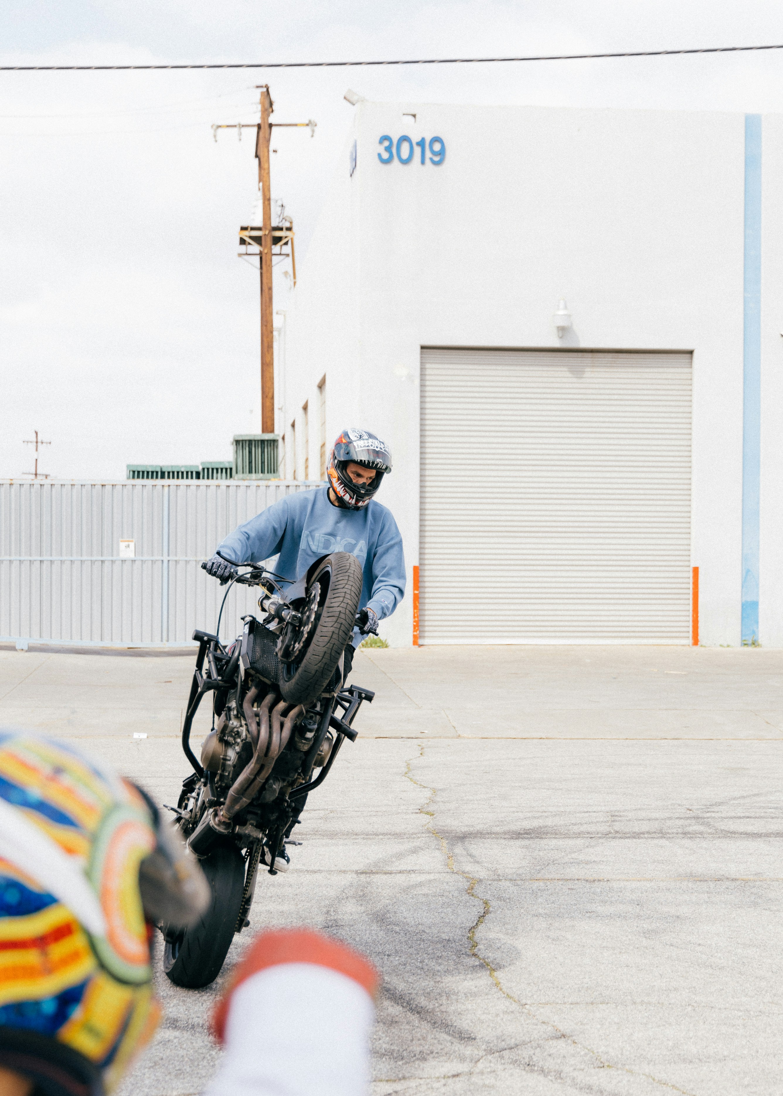Skidding Toward Focus: Rider Lifts a Bike in an Industrial Courtyard