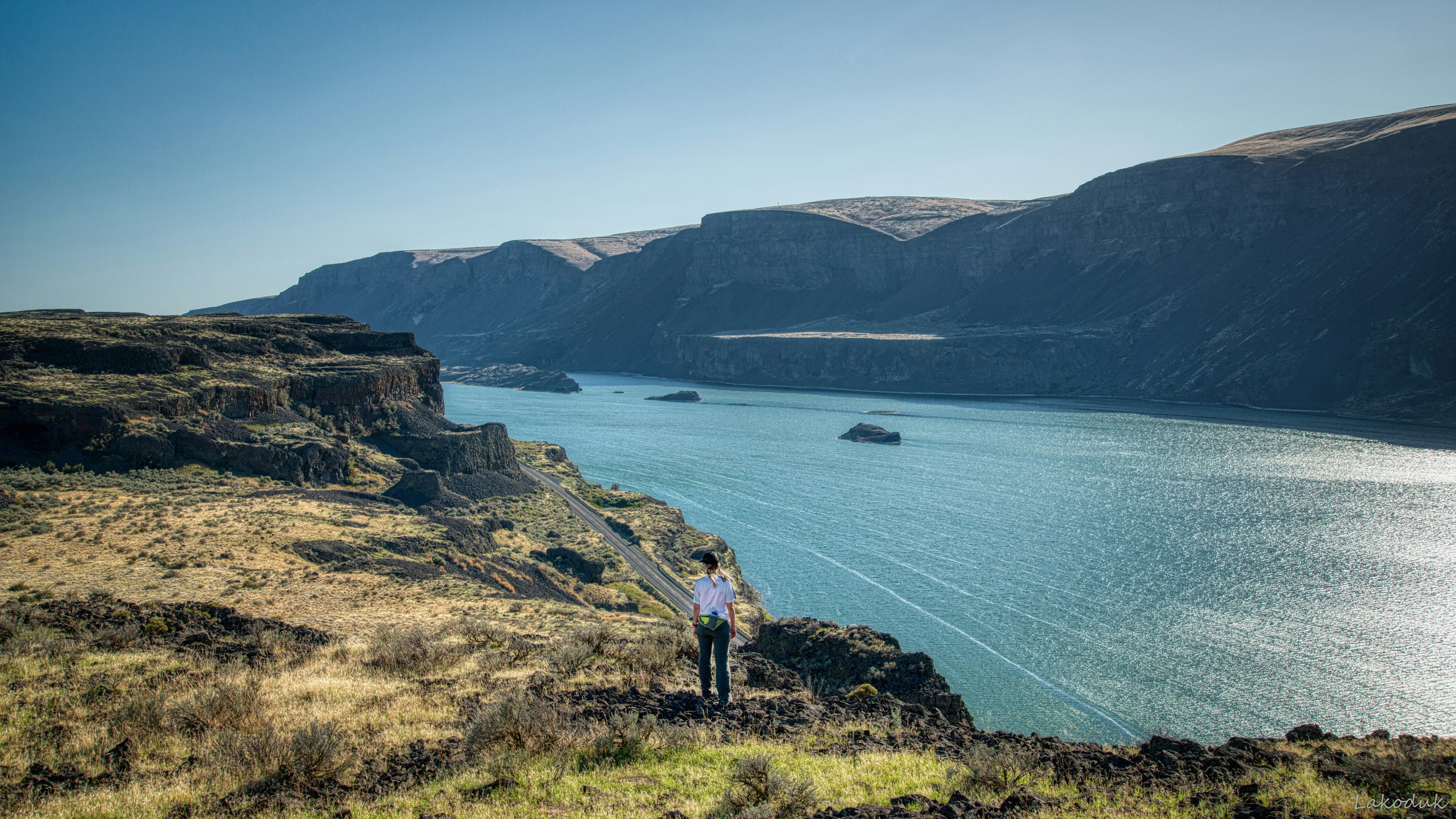 On the Cliff's Edge, Quiet Fjord: A Lone Walker Sees the Blue Expanse
