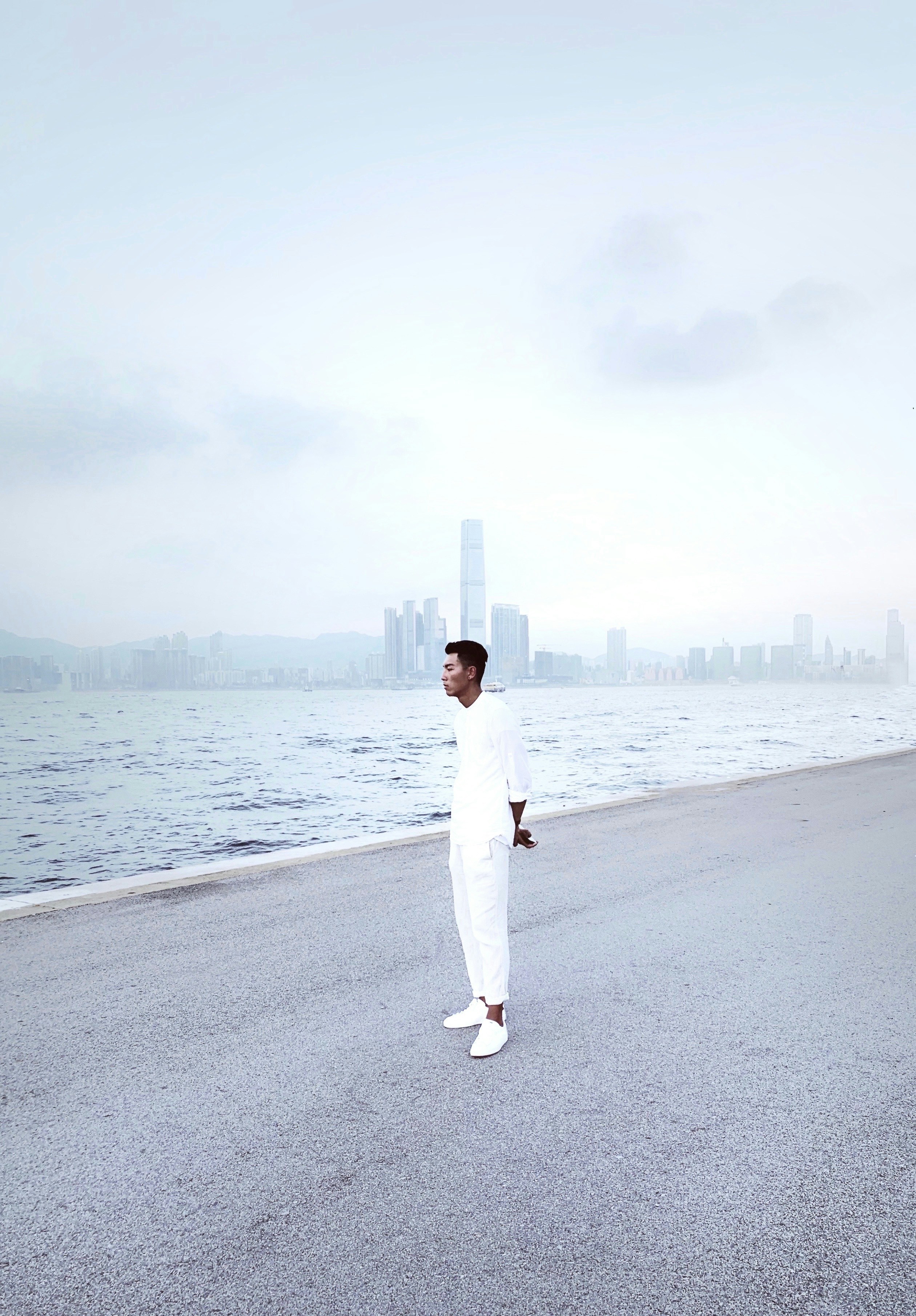 White-clad silhouette at a fog-kissed shoreline promenade