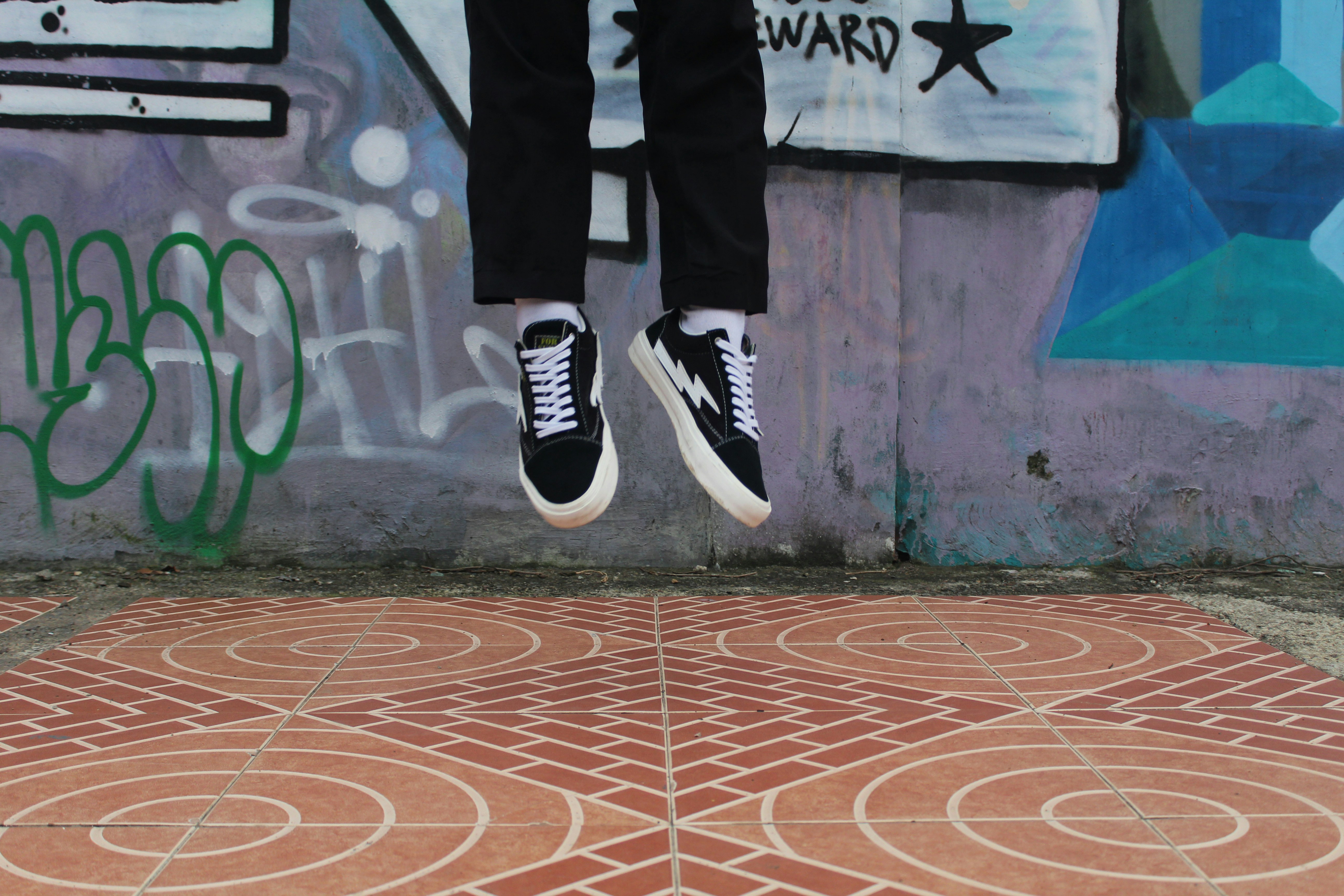 Sneaker Leap Above Graffiti: Hovering Over Circular Tile Spirals