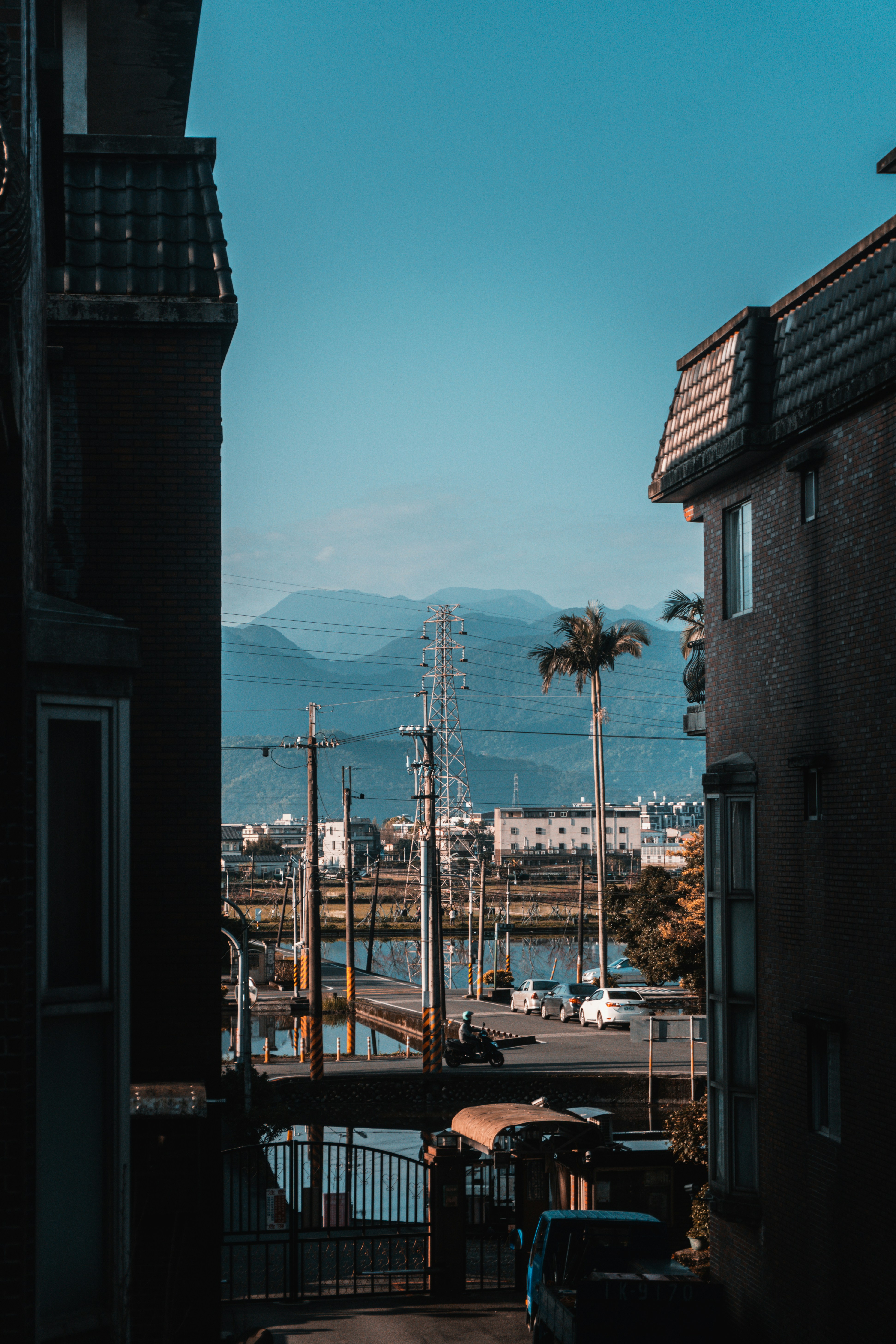 Framed Between Brick Towers: Distant Peaks Across a Narrow Street