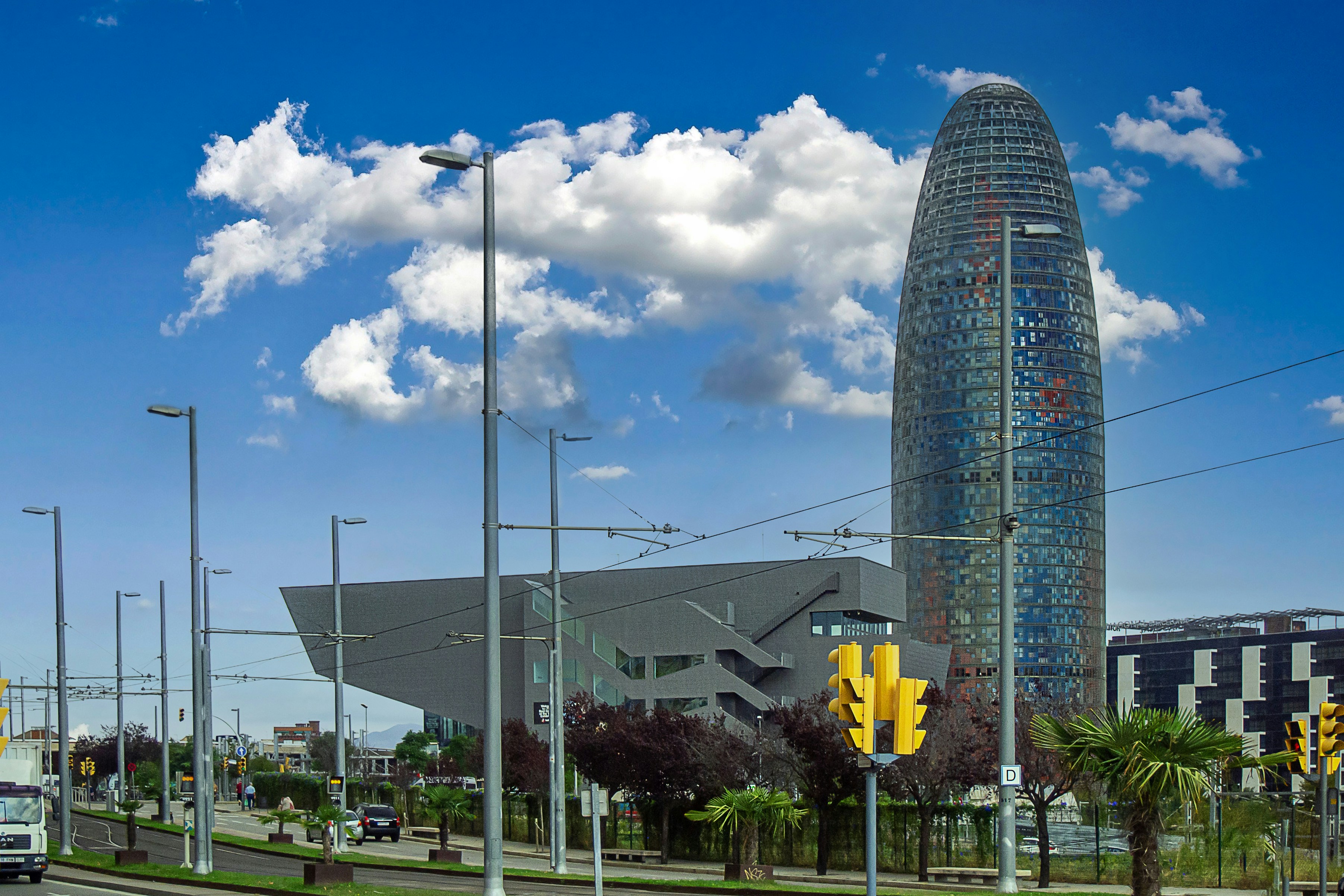Barcelona's Torre Glòries: Glassy Colossus over a palm-lined cityscape