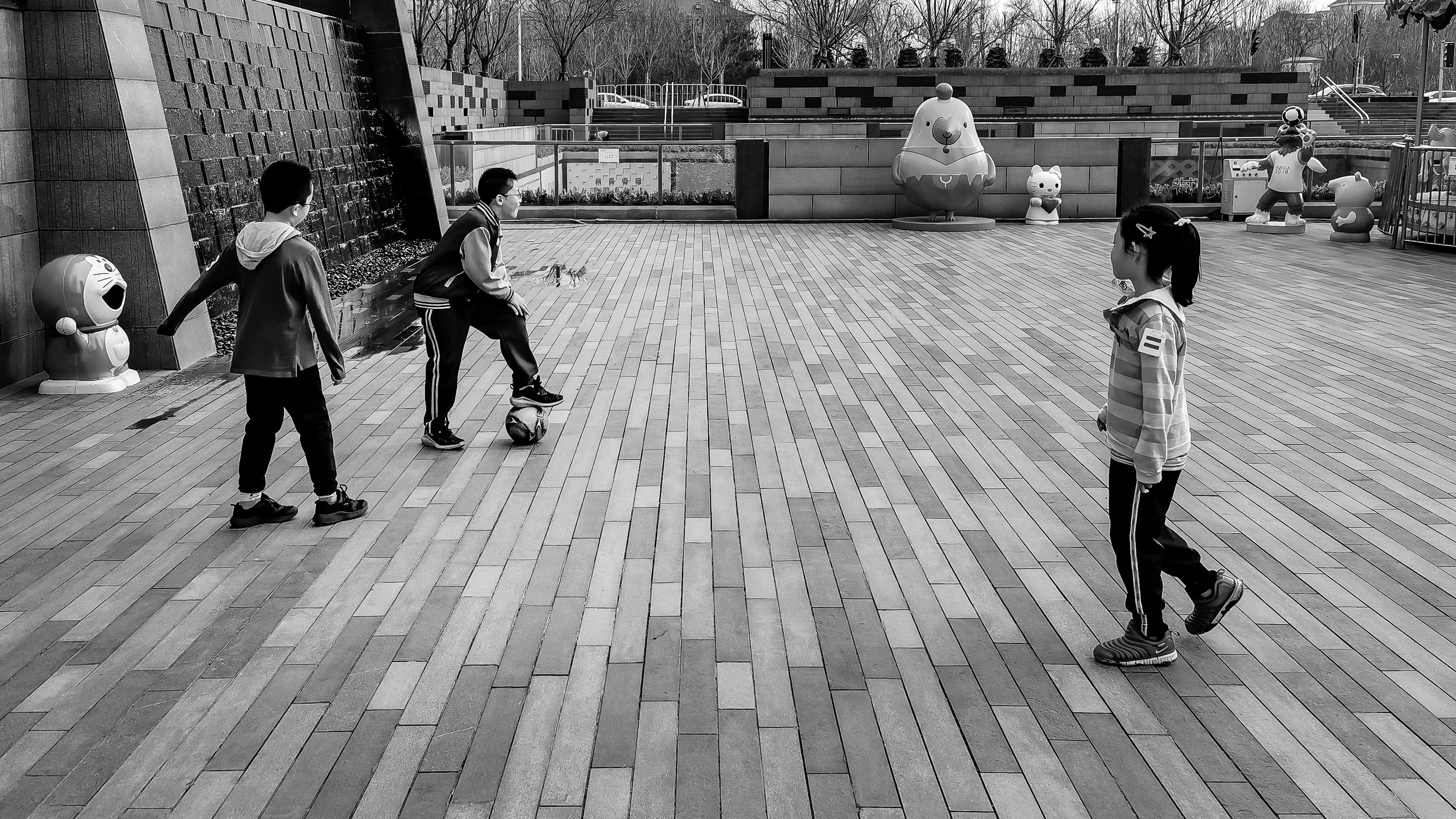 Children engaged in a lively game of soccer on a vibrant playground, surrounded by playful characters and colorful decor.