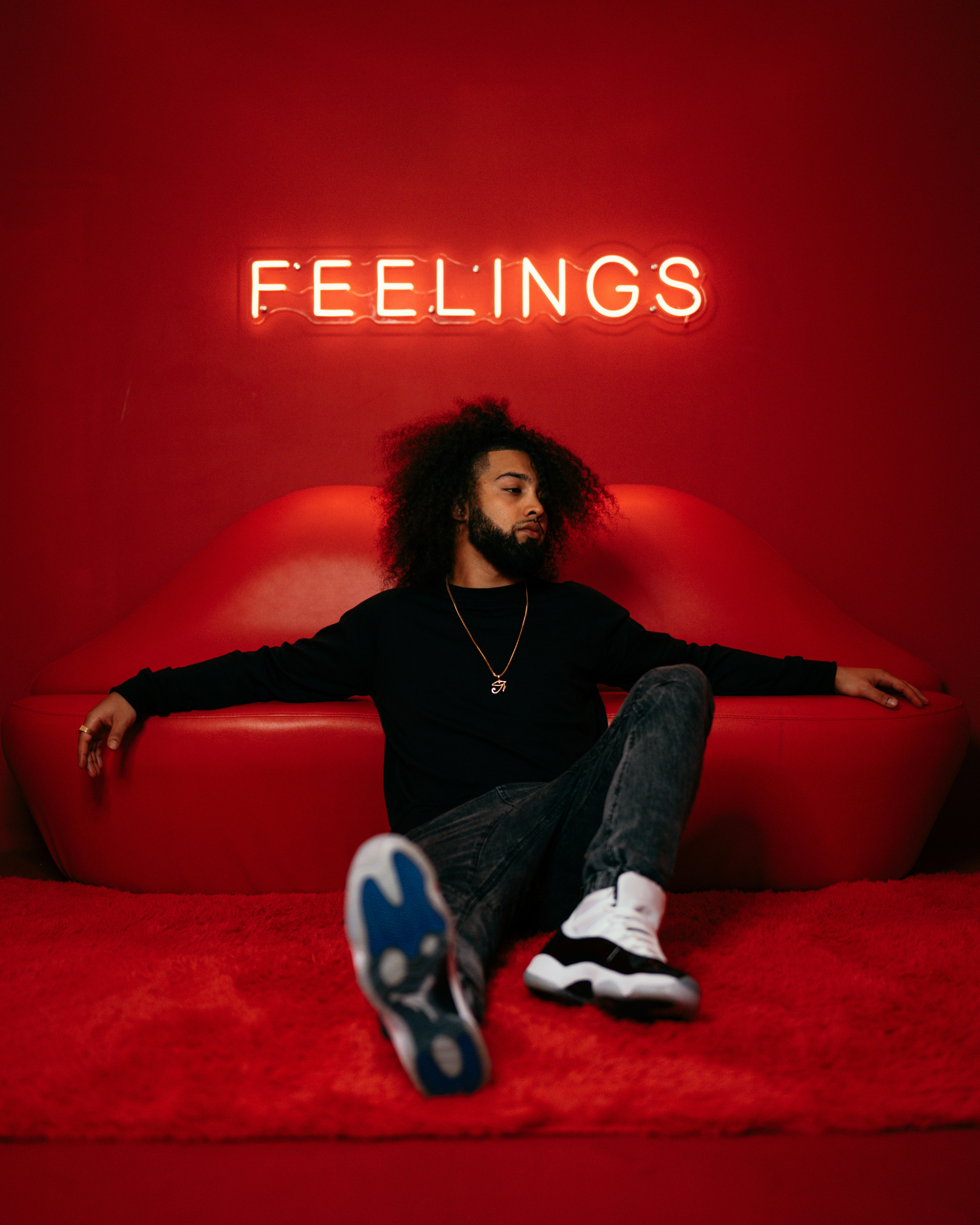 Woman in black long sleeve shirt and black pants sitting on red couch ...