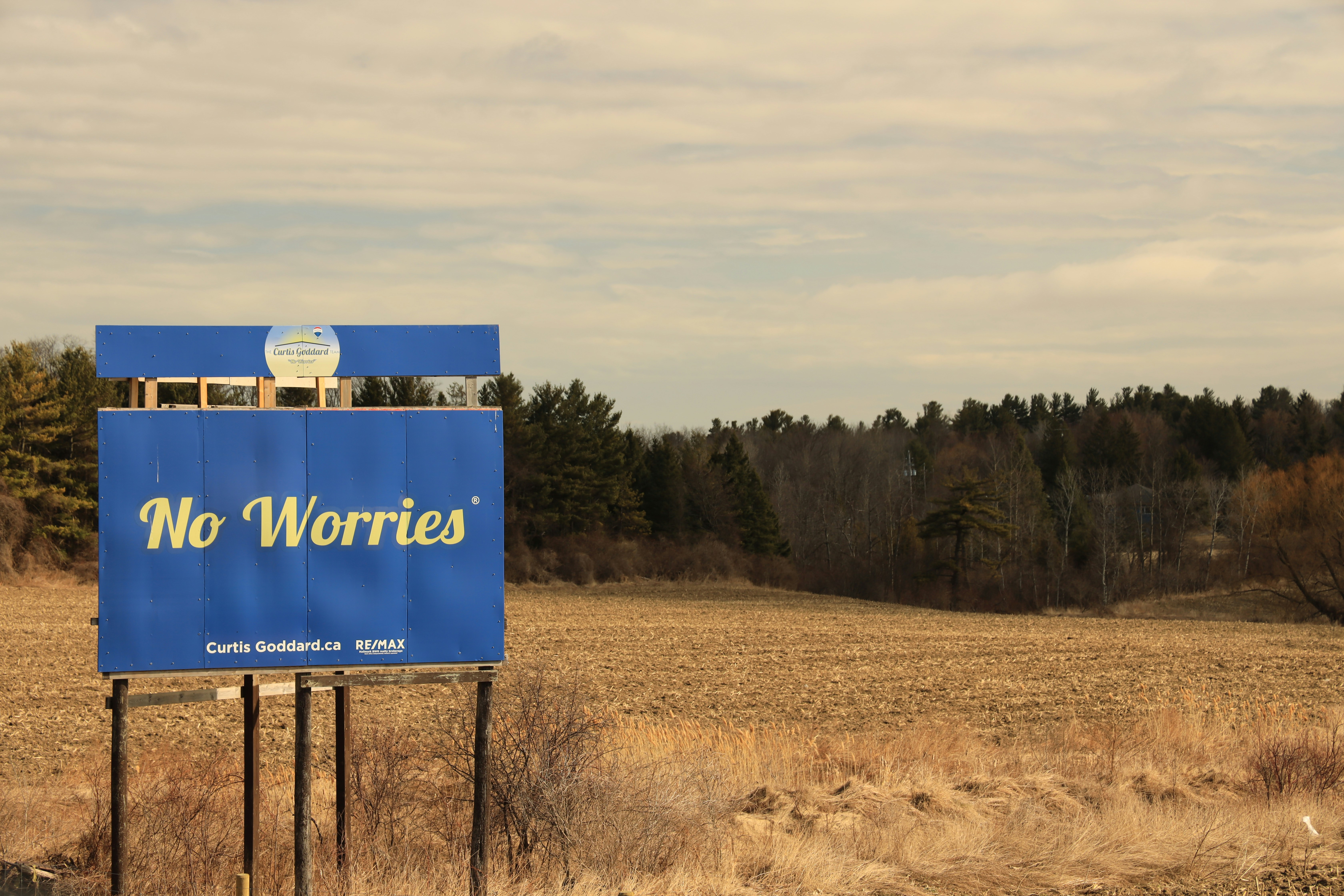 Blue and white wooden signage on brown grass field during daytime photo ...