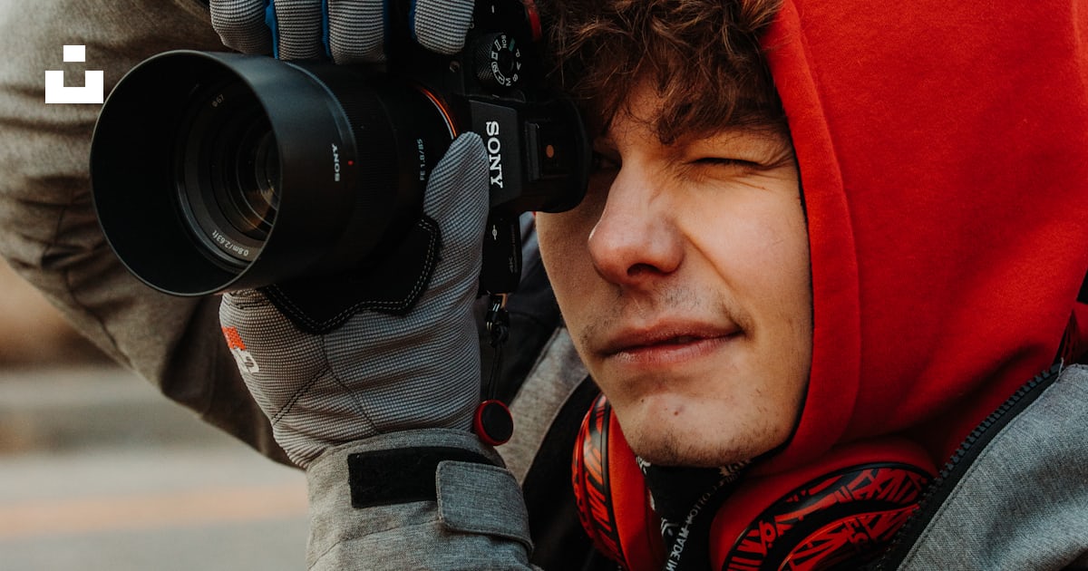 Hombre Con Sudadera Con Capucha Roja Sosteniendo Una Cámara Dslr Negra