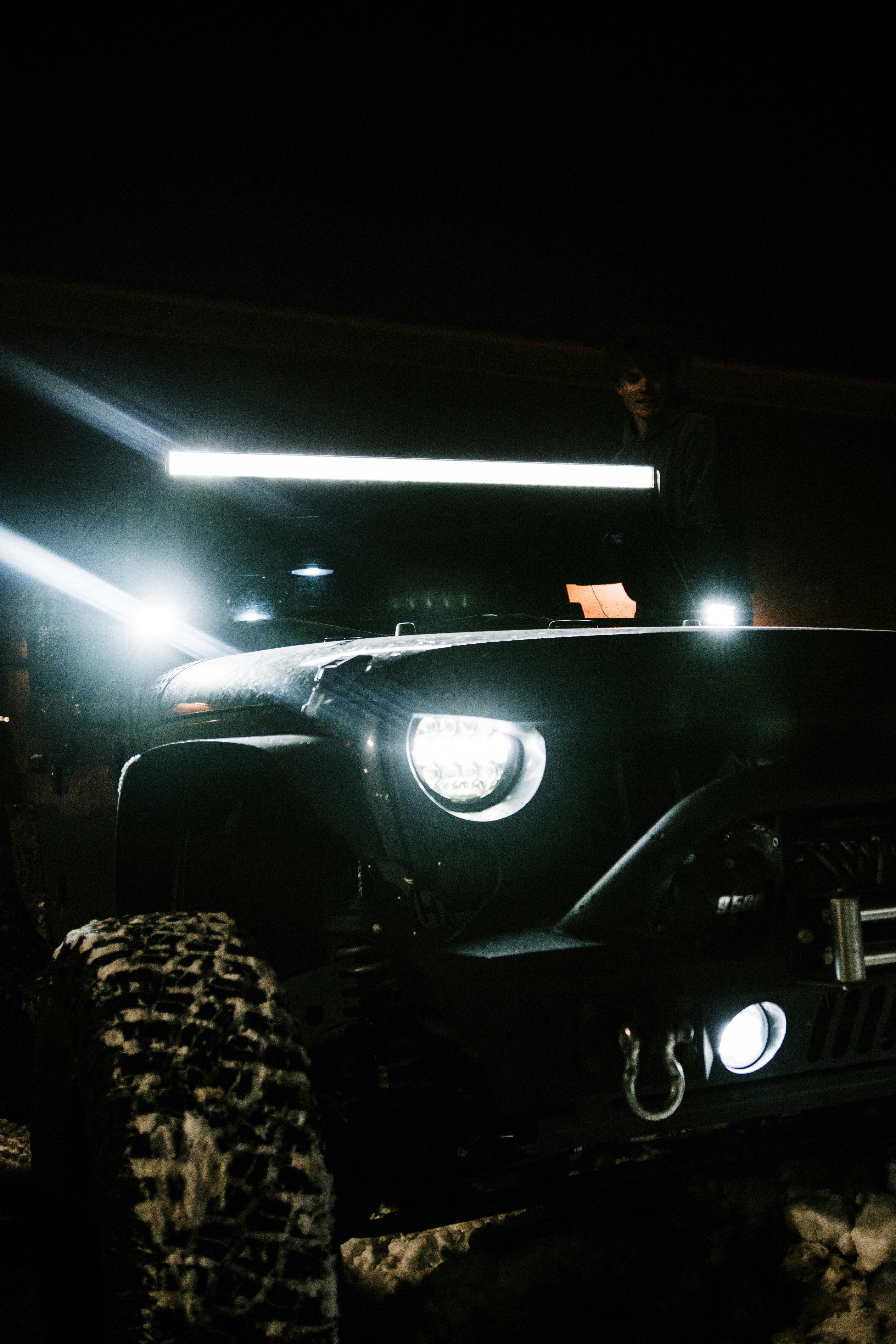 Foto Hombre con chaqueta negra parado al lado de un auto negro – Imagen ...