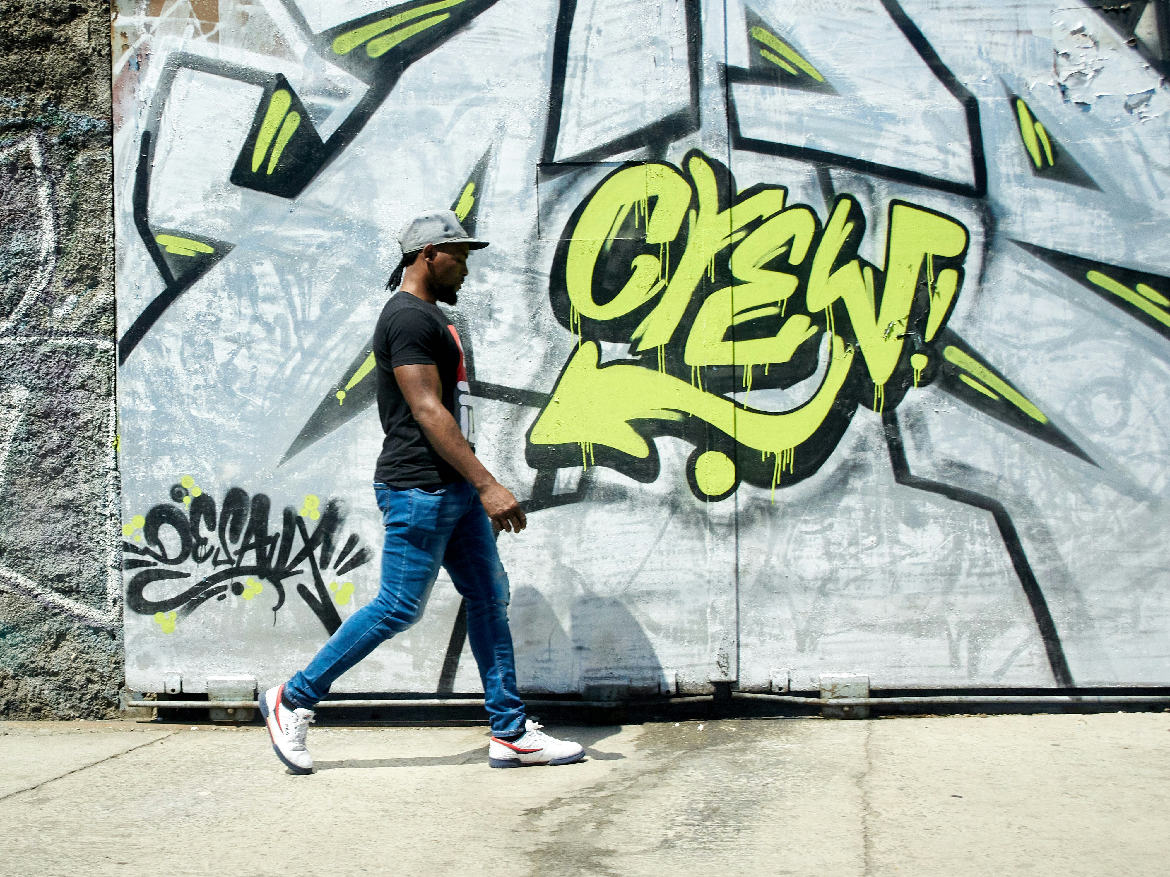 Mujer con camiseta sin mangas gris y jeans de mezclilla azul de pie ...