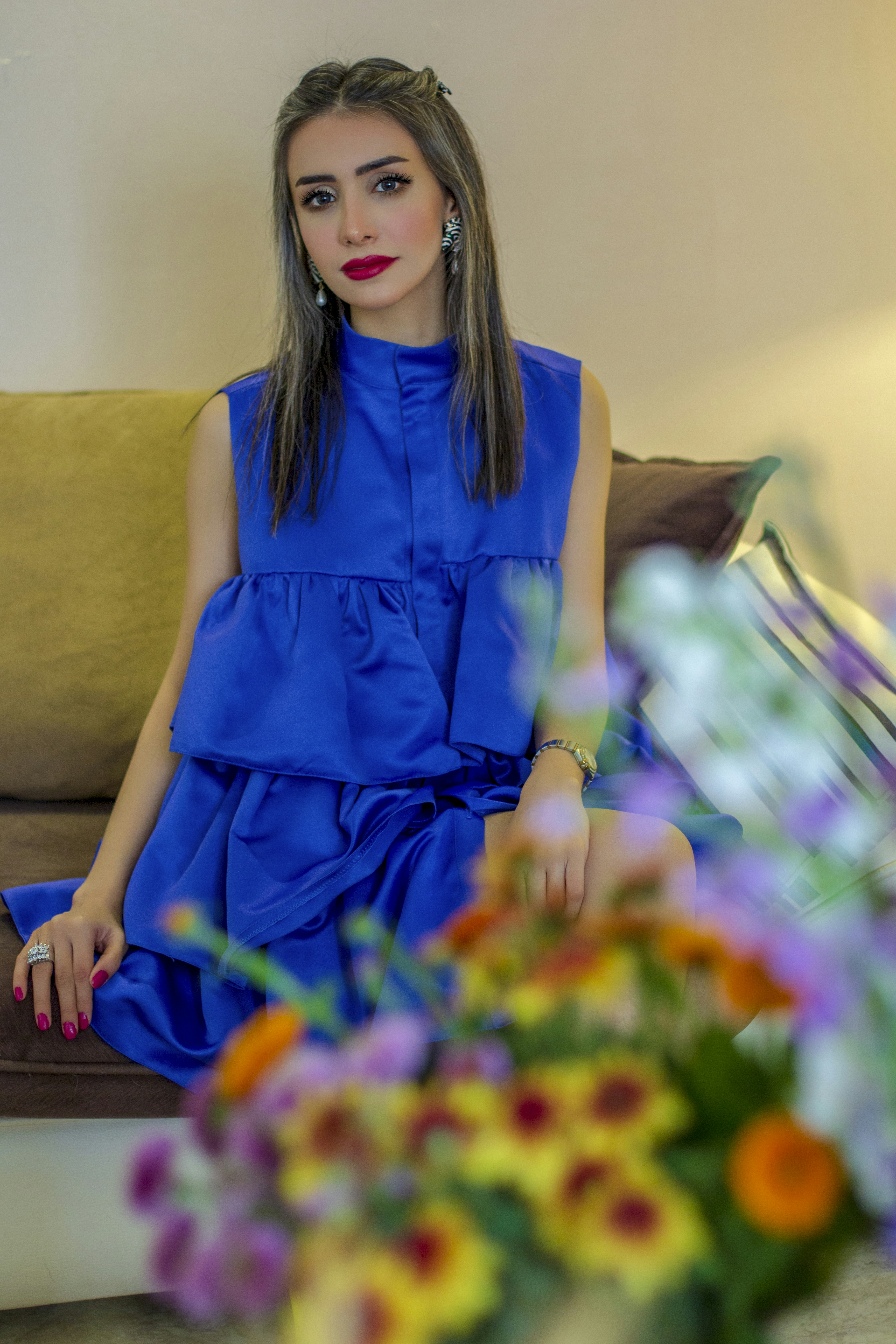 girl in blue dress sitting on brown couch