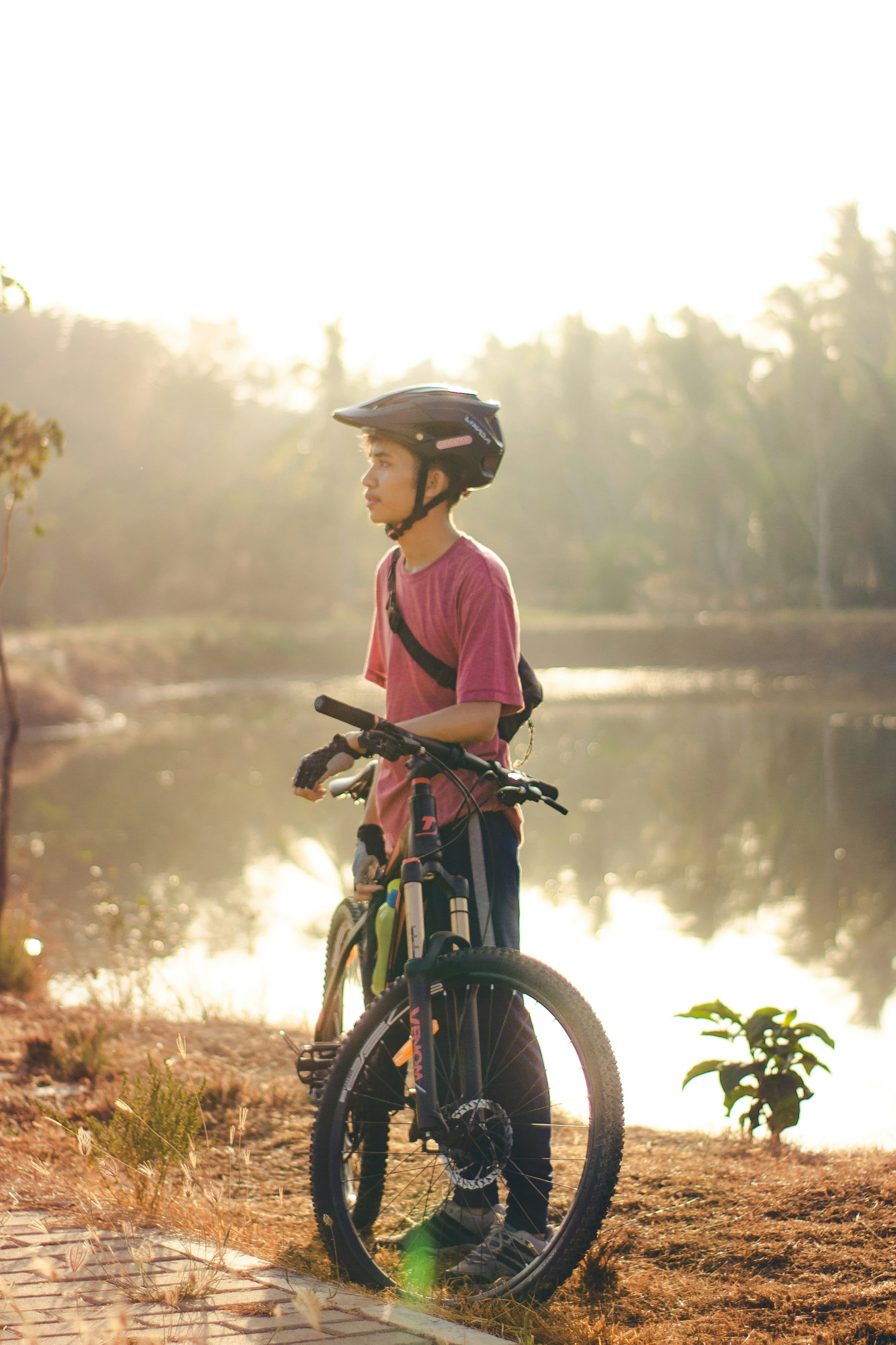 Man in white crew neck t-shirt riding bicycle near body of water during ...