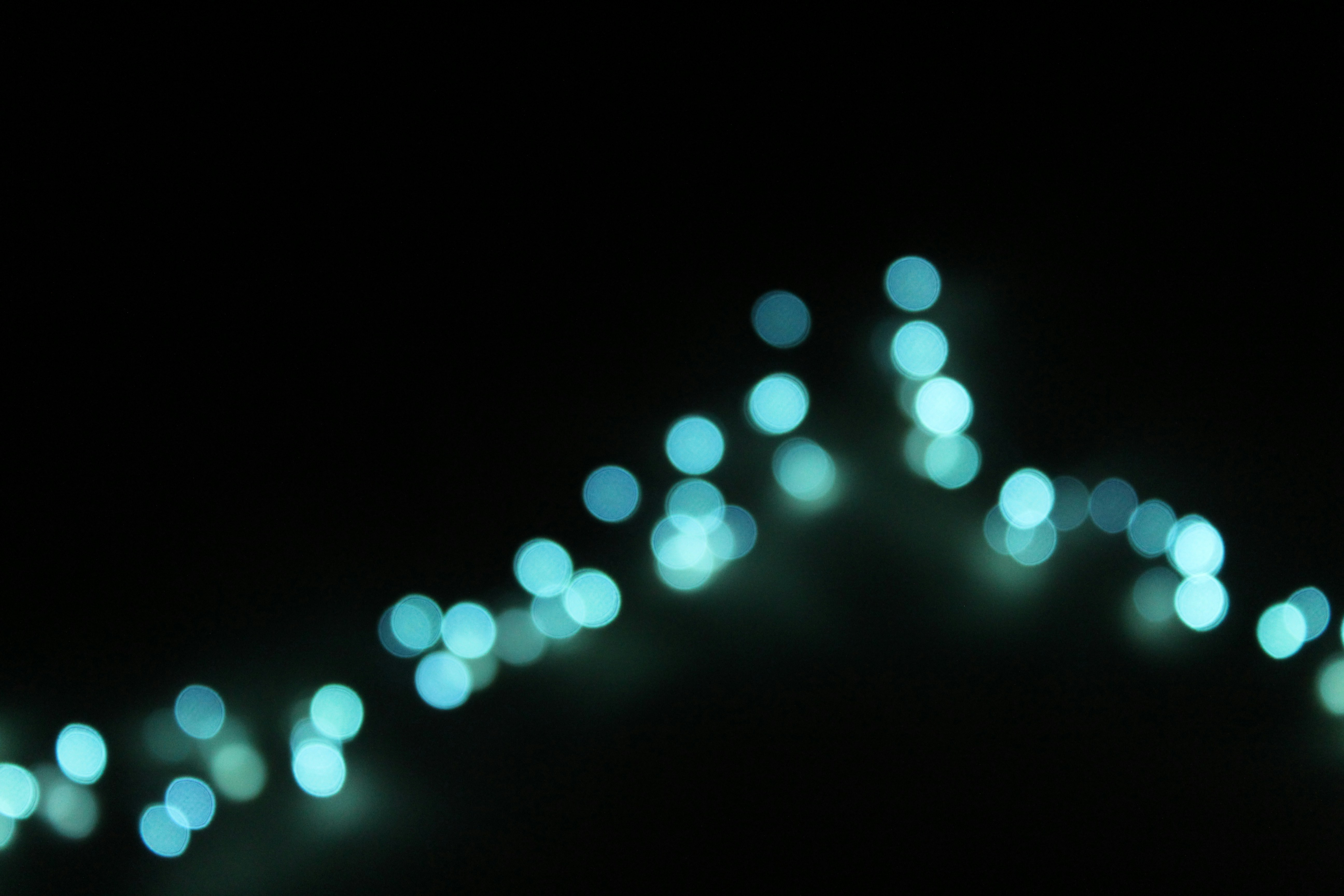 Soft blue bokeh lights creating a dreamy atmosphere against a black background.