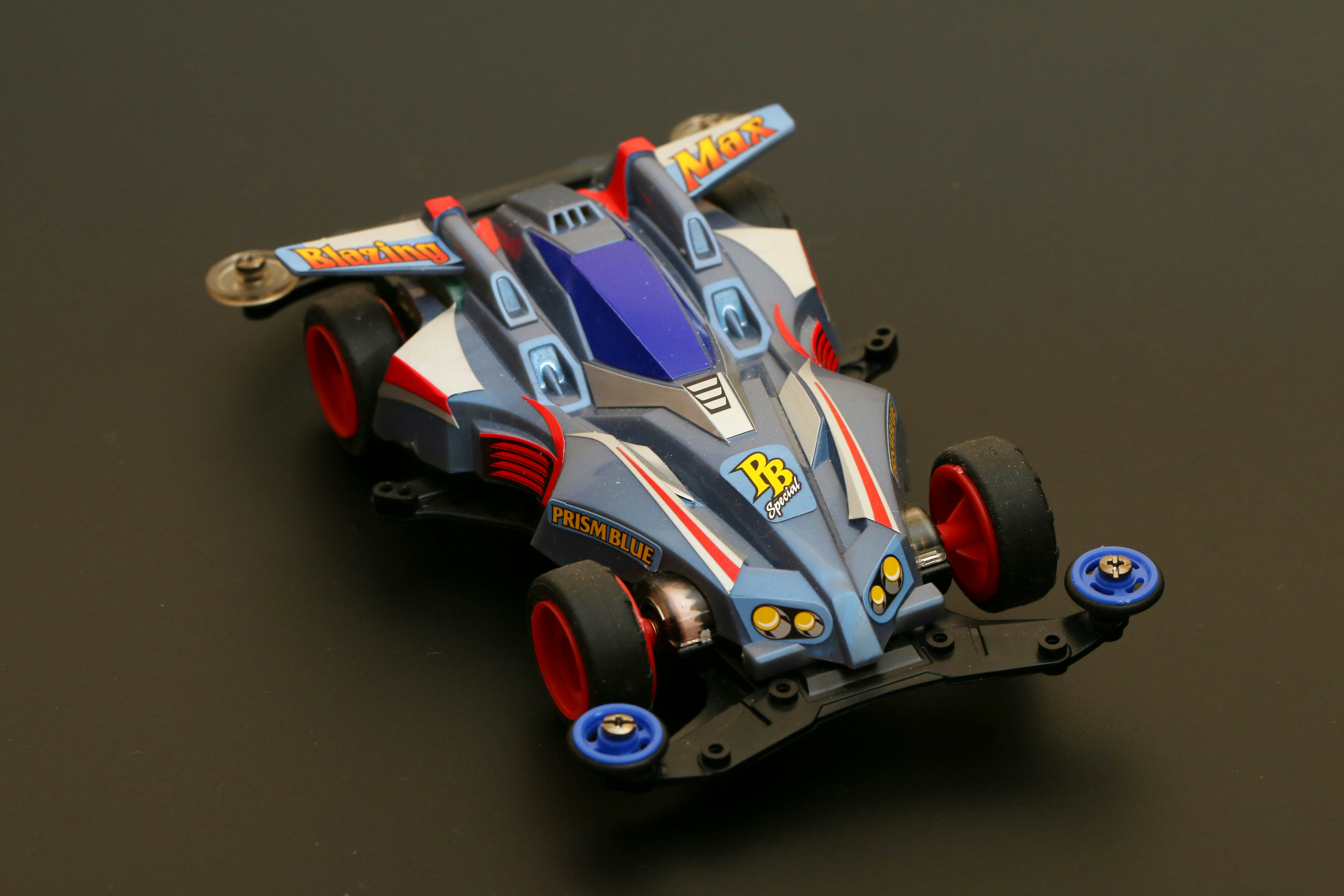 Detailed model race car with vibrant colors and intricate design elements, showcasing speed and precision. The sleek body and dynamic features highlight its racing heritage.