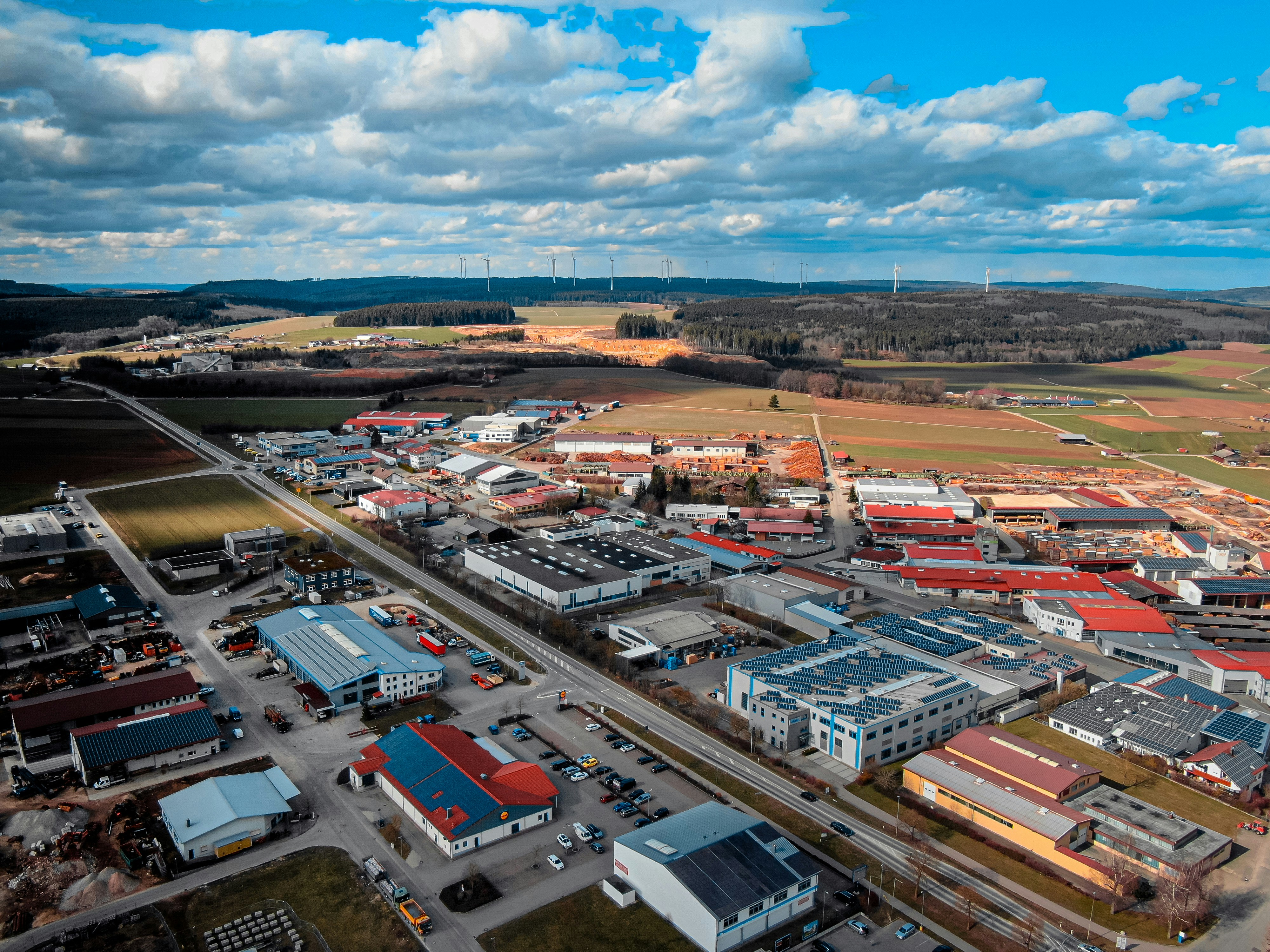 Industrial Arcade: Aerial View Over Factory Rows and Wind Turbines