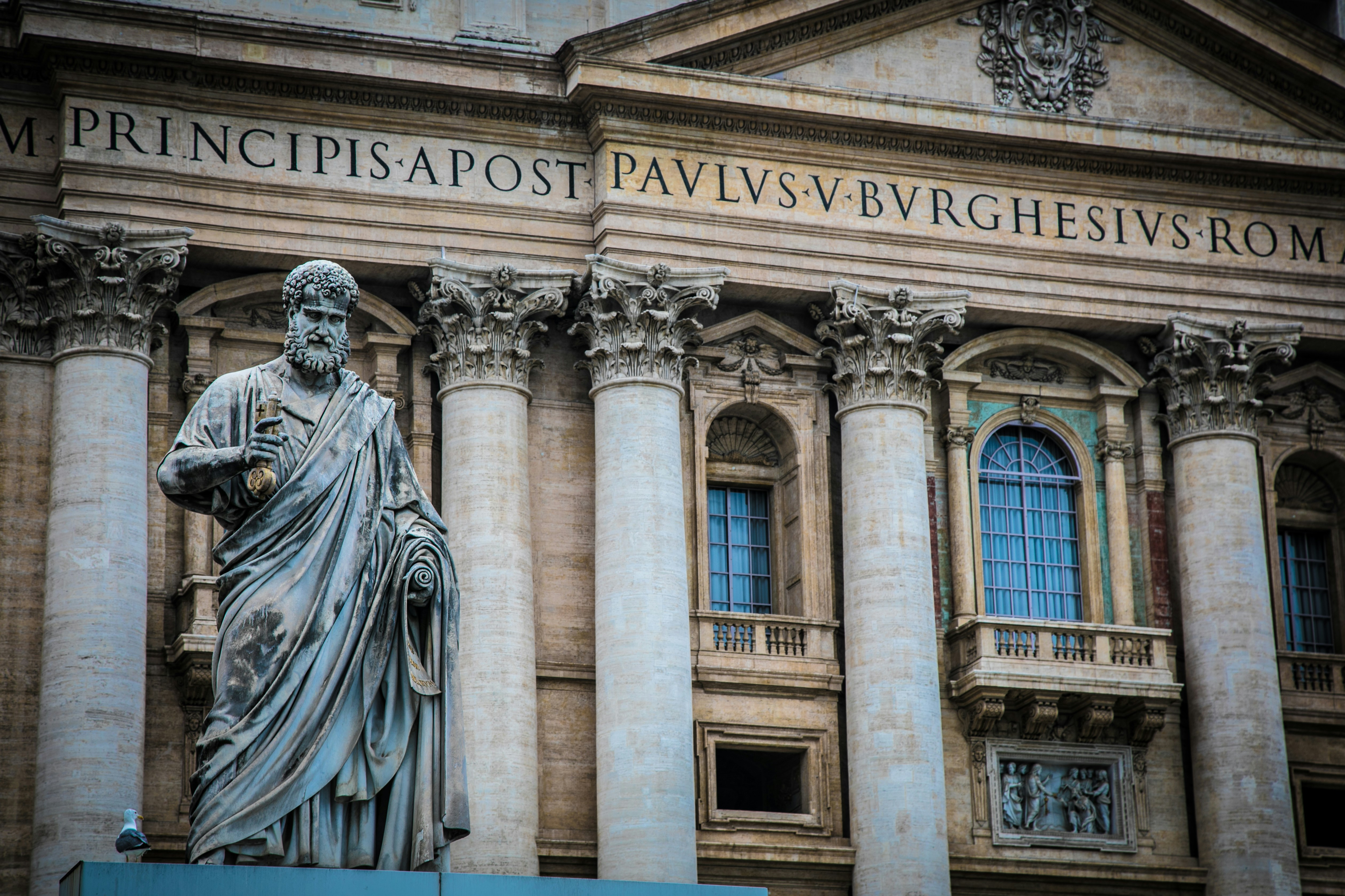 Stone Sentinel Against a Marble Crown: Statue Guards a Monumental Facade