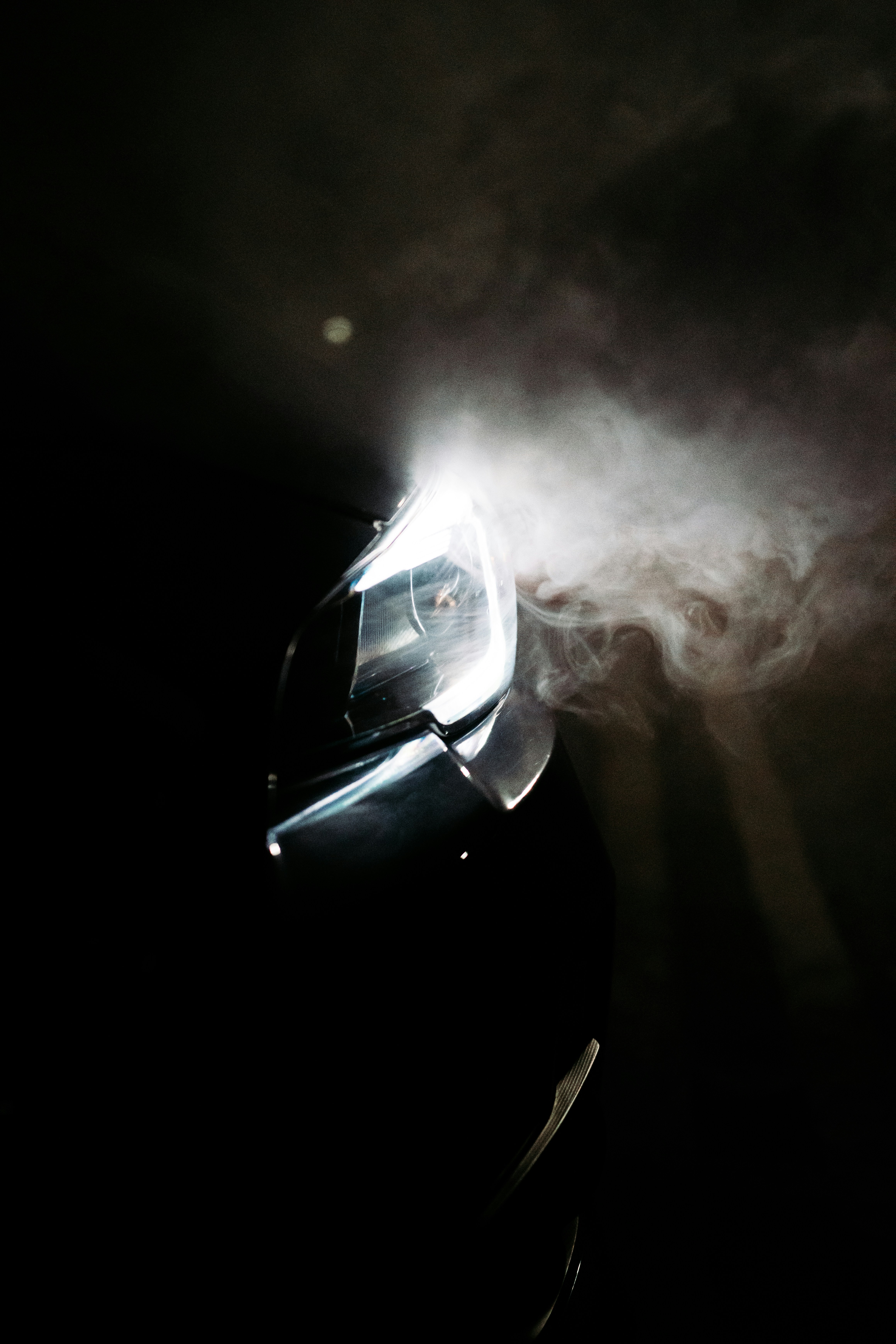 Midnight Beam: Smoke-Clad Headlight Pierces the Dark