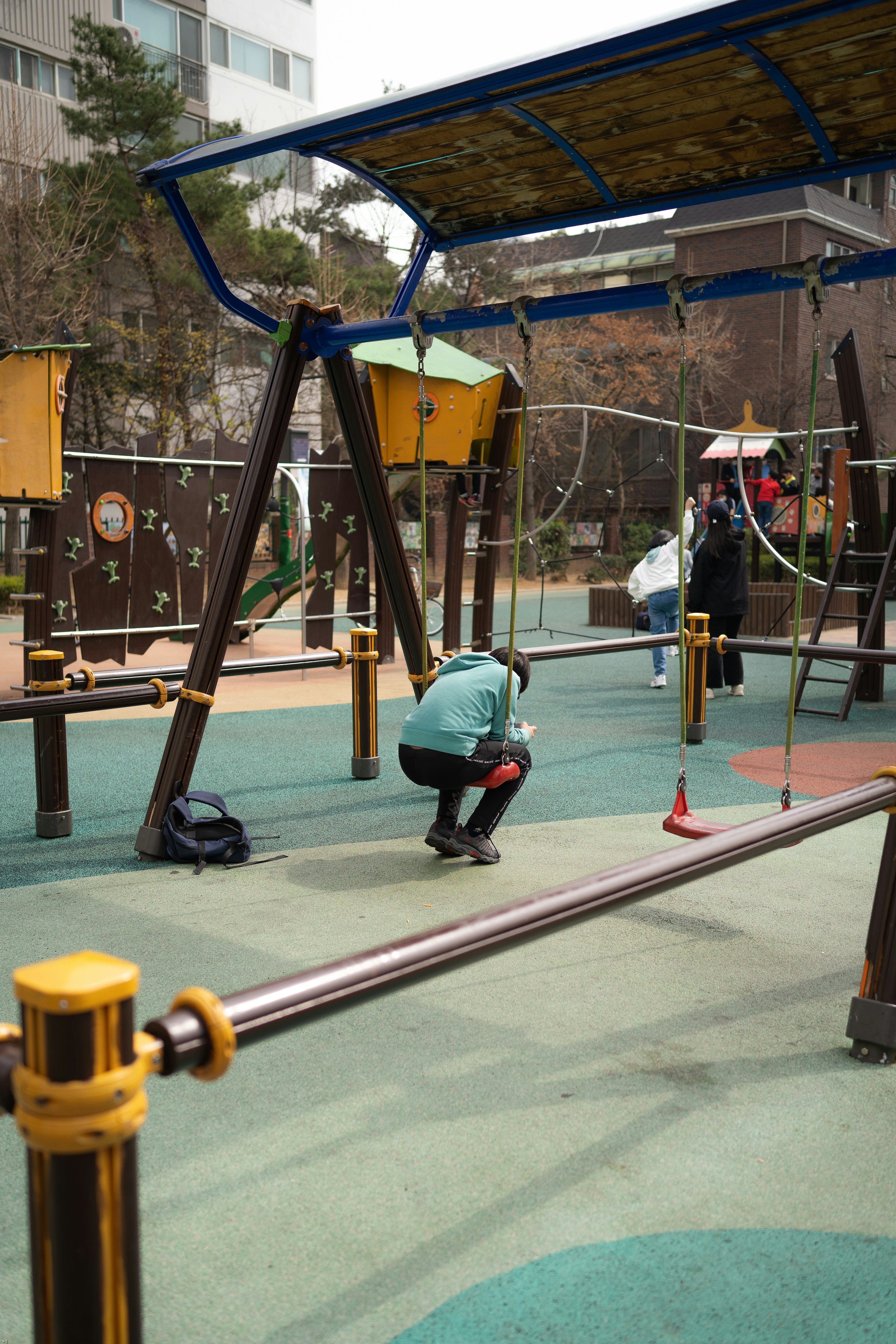 a child sitting on a playground swing
