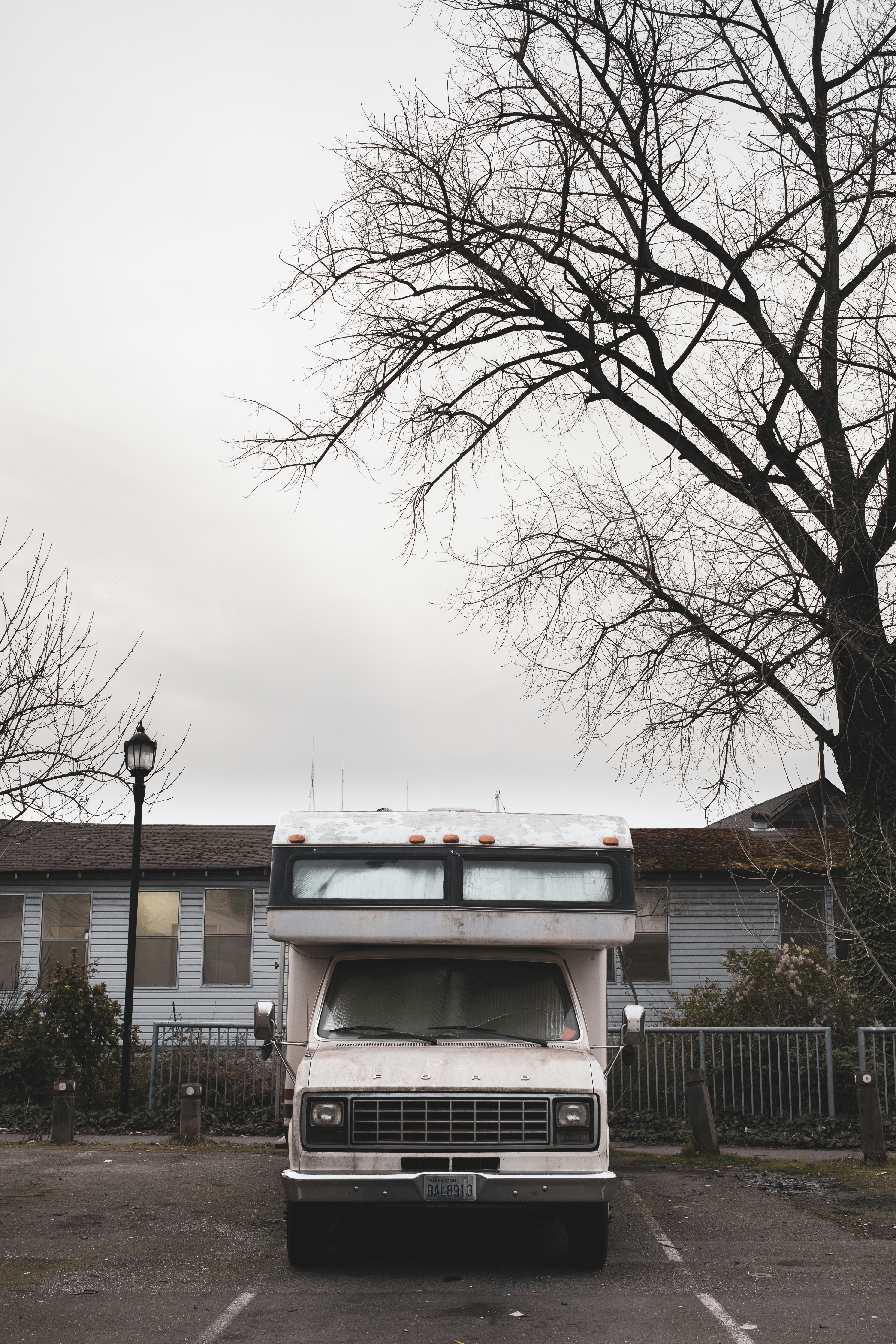 Front View of a Weathered RV Framed by Winter Trees in a Quiet Lot