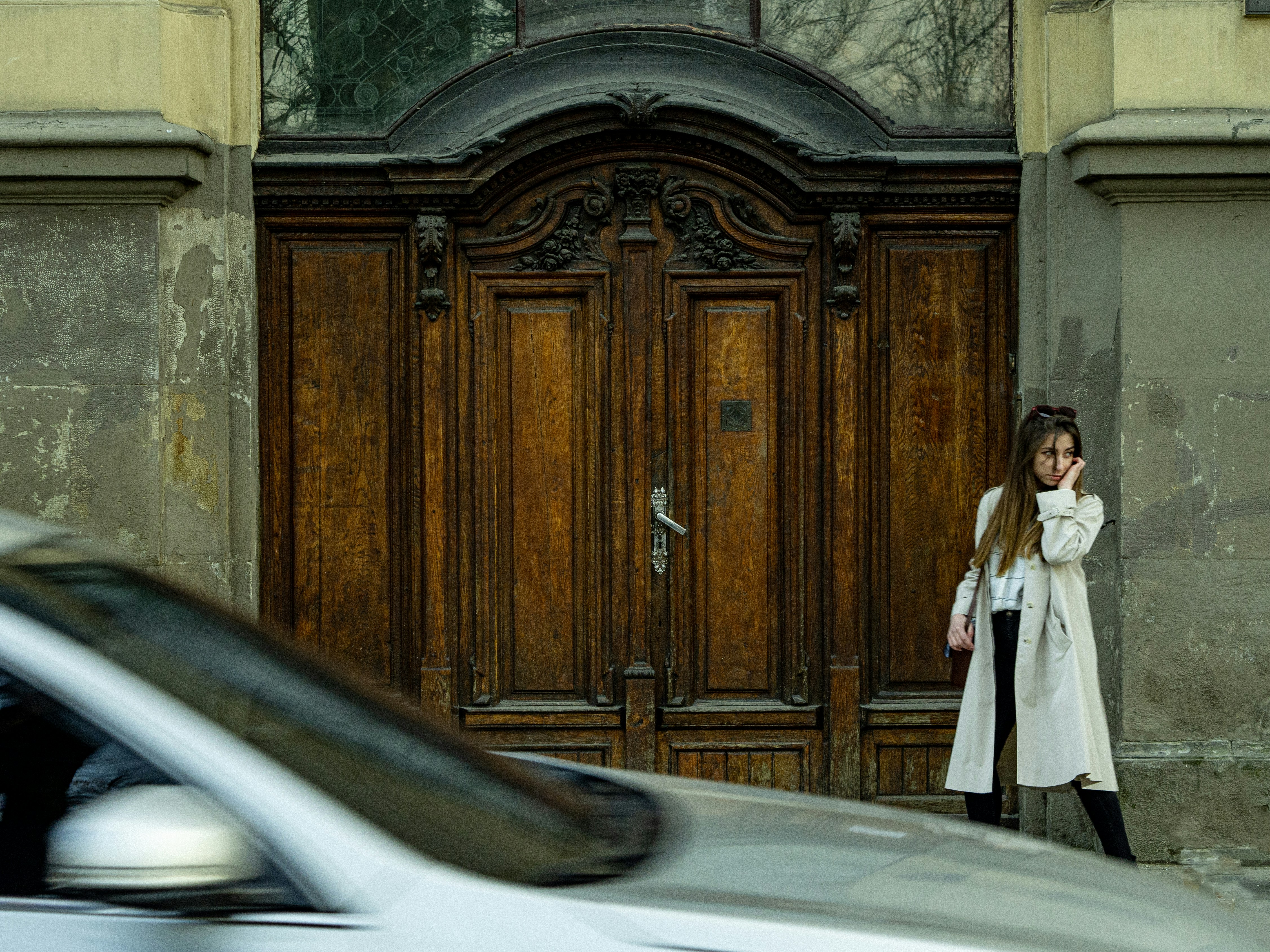 Girl in Coat by Weathered Doors