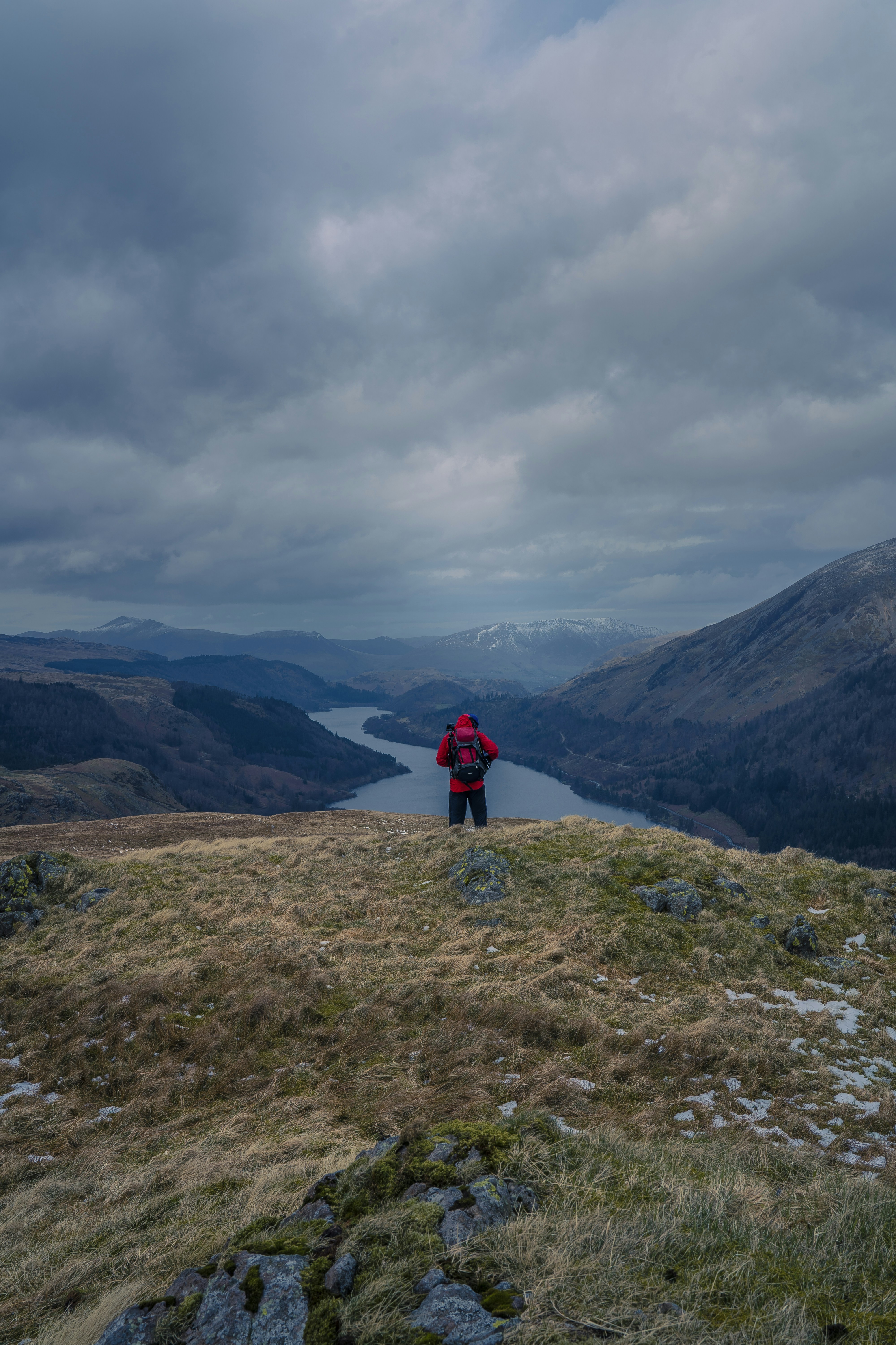 Person in red jacket standing on brown grass field during daytime photo ...