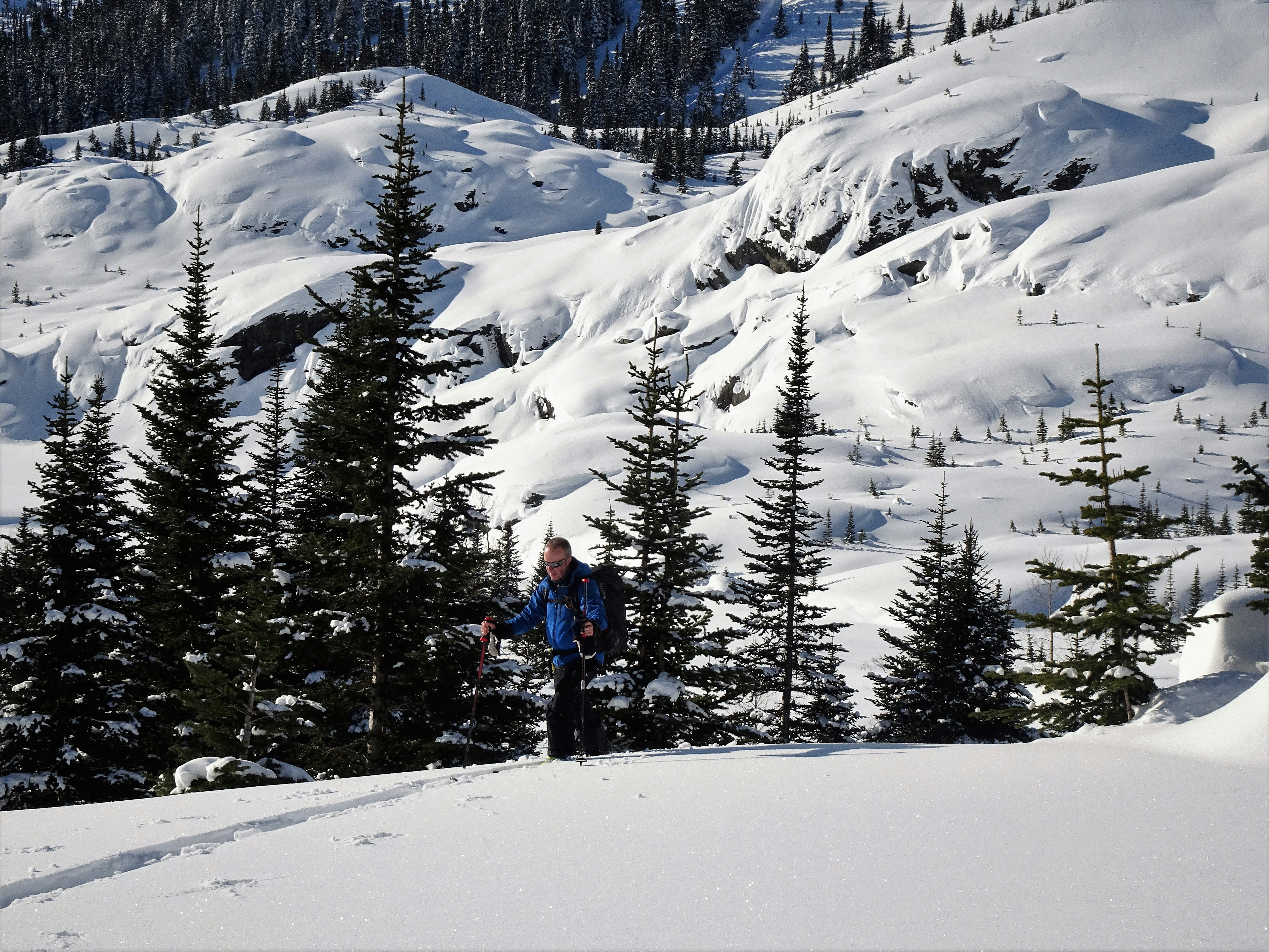 Skinning up to the lodge last year, March 2020... | person in red jacket and black pants standing on snow covered ground during daytime