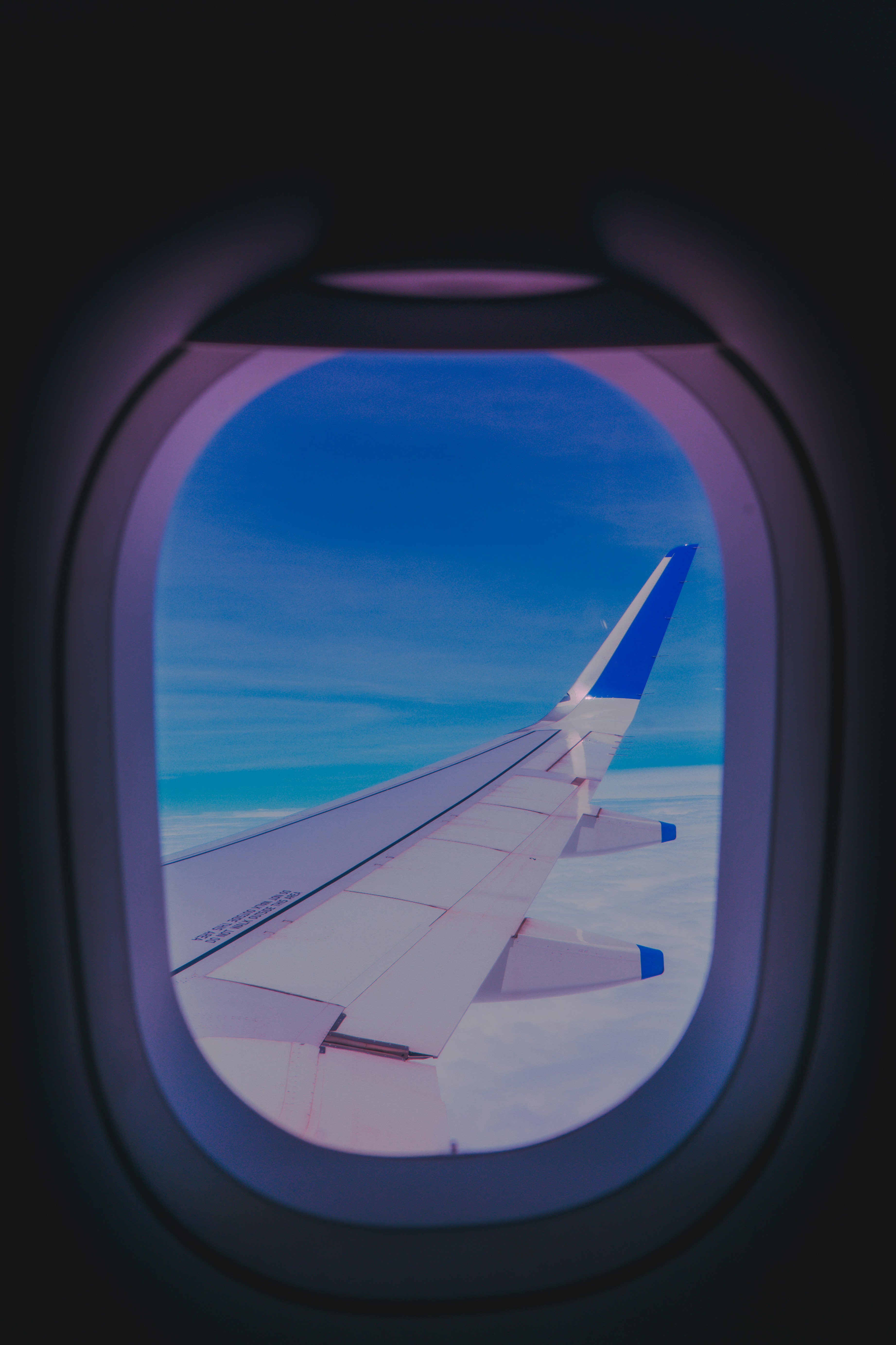 Wingline Through the Pane: A Window-Seat View of Blue Sky and Jet Wing