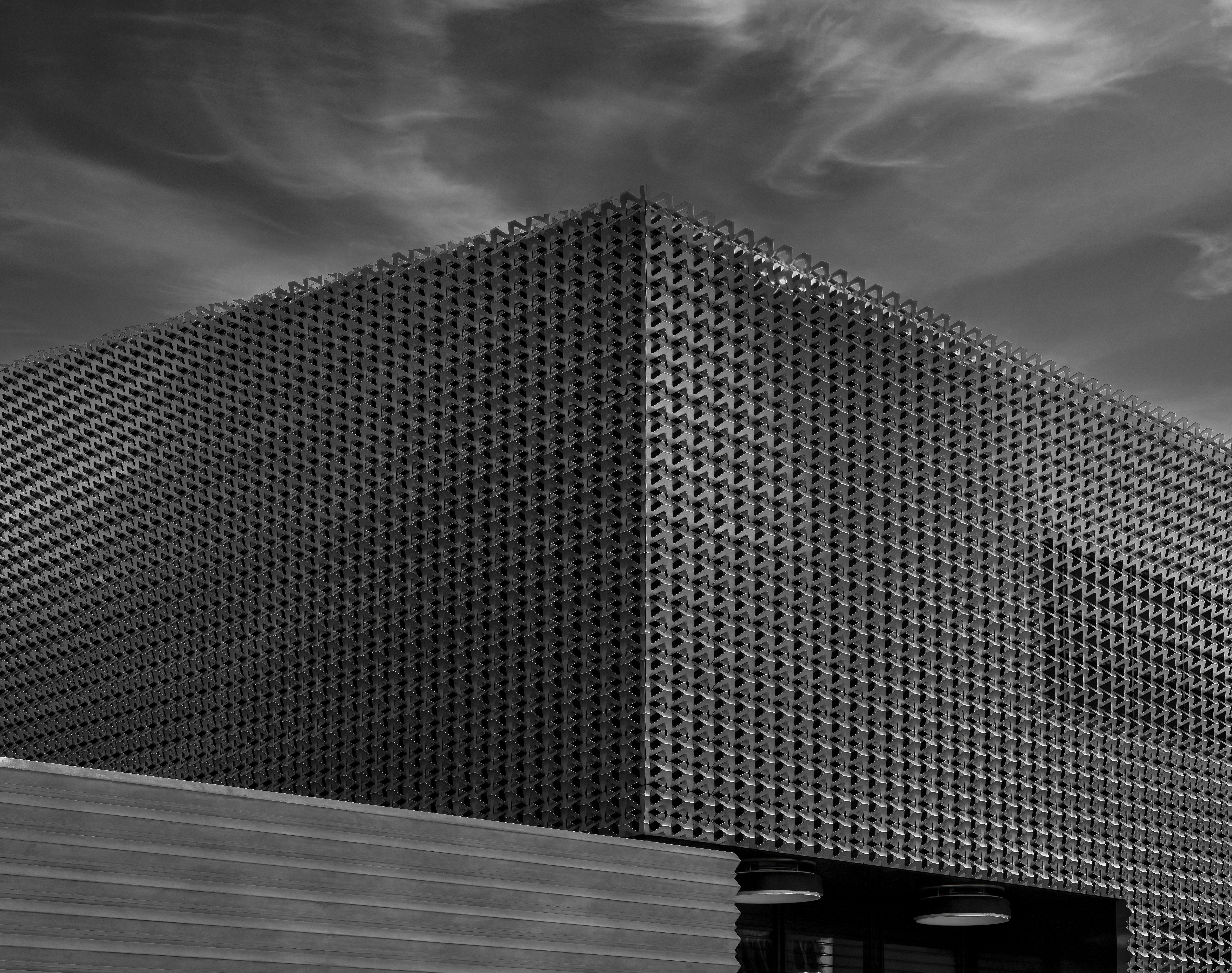 Beautiful textures and light | grayscale photo of building under cloudy sky