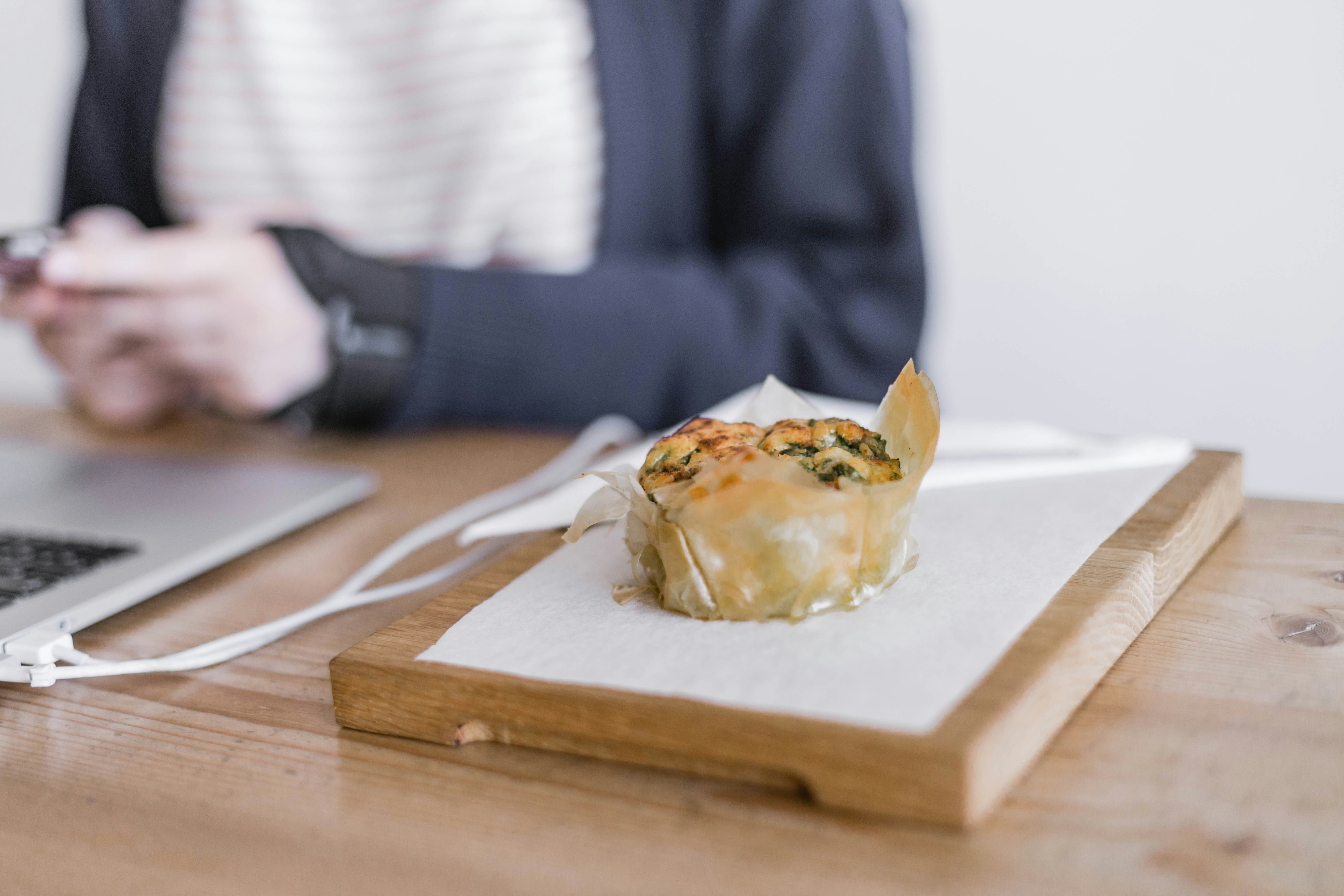 Herb-Topped Pastry on a Wooden Board: A Quiet Desk Moment