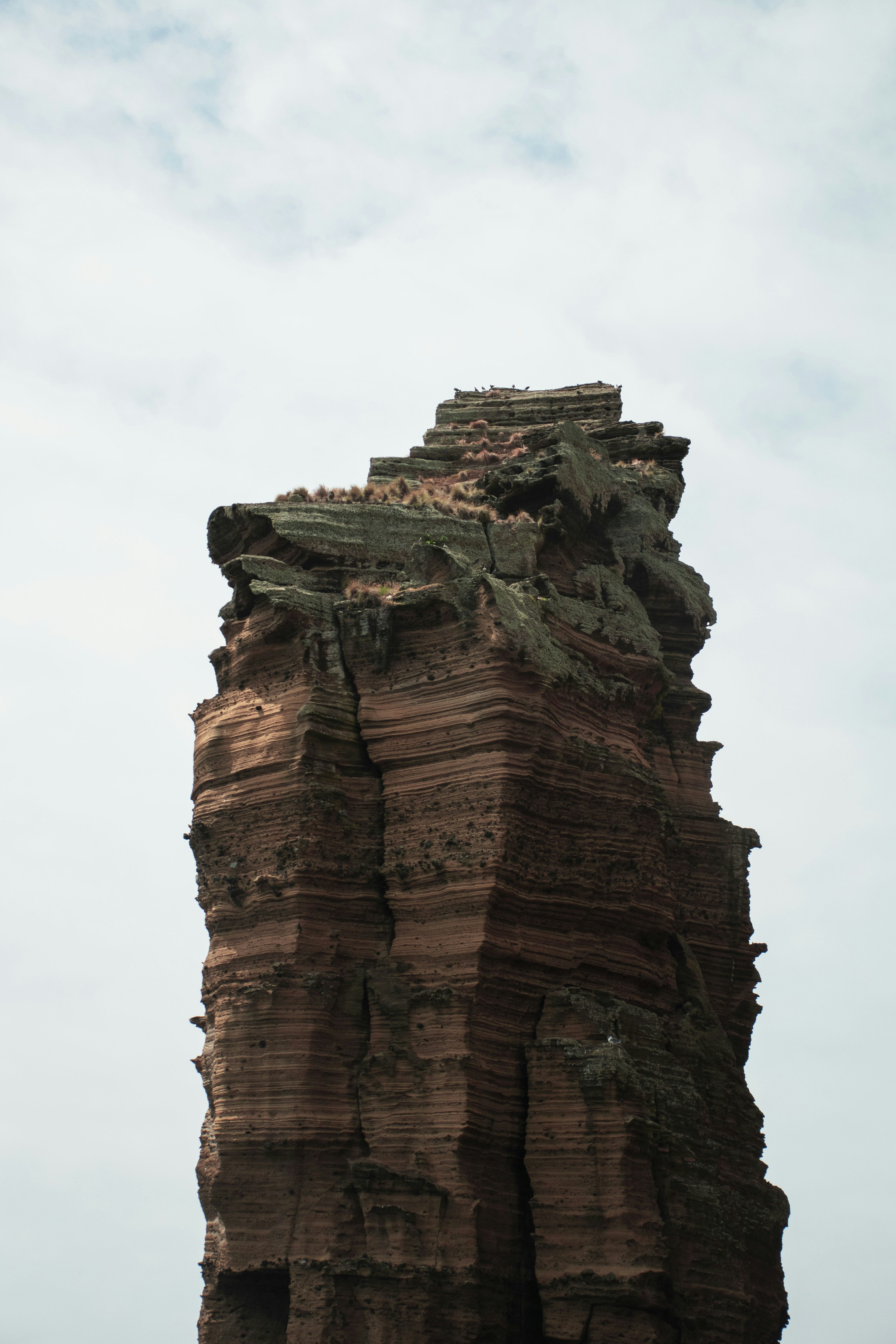 Redstone Spire: Weathered Stratified Monolith against a Pale Sky
