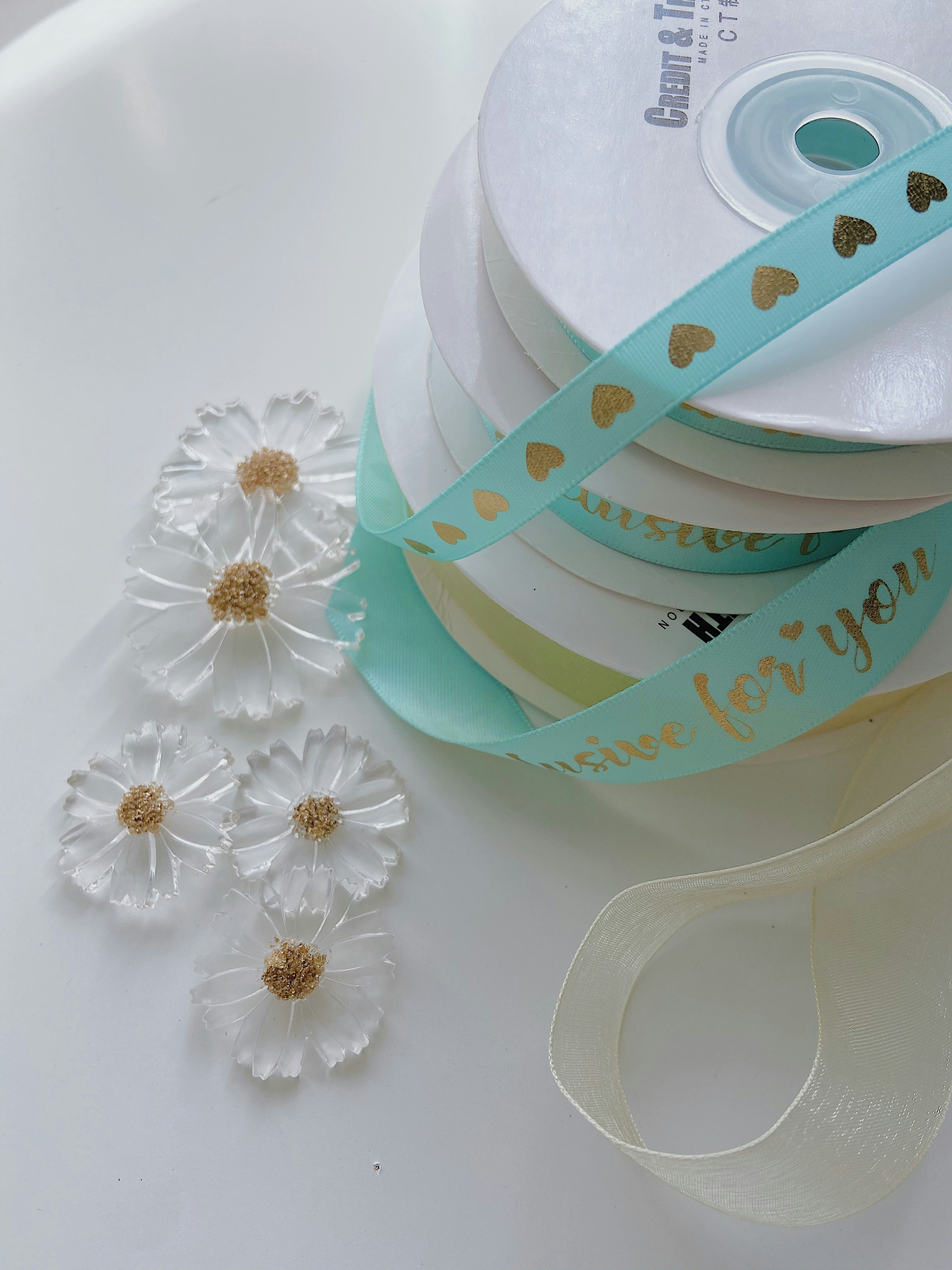 Pastel Ribbon Stack and Daisies under Soft Studio Light