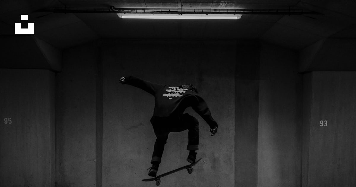 灰色のコンクリートの床に飛び跳ねる黒と白の長袖シャツと黒のズボンを着た男の写真 Unsplashのストリートフォトグラフィーの無料画像