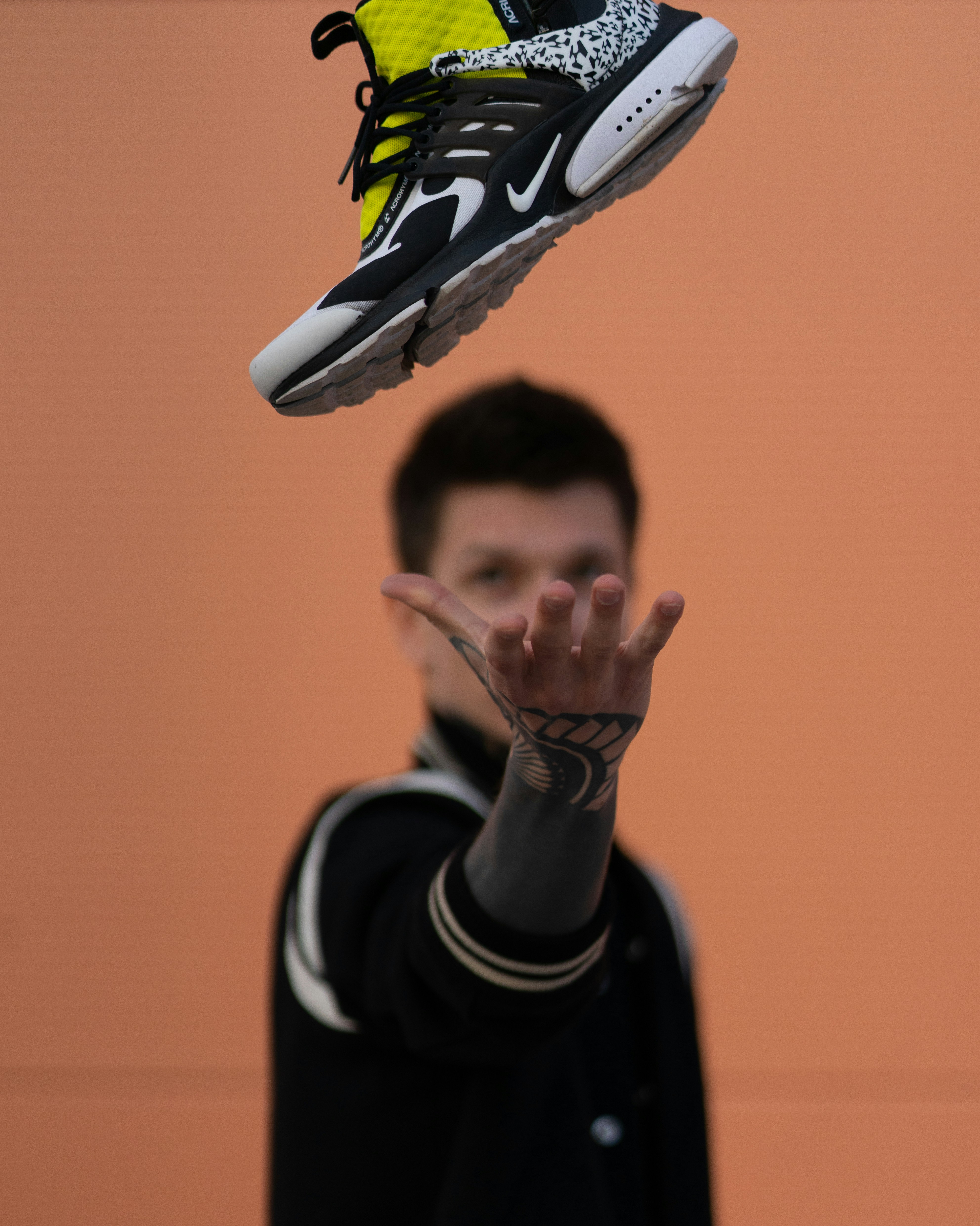 Hover Kick: Neon Sneaker Suspends Above a Reaching Hand
