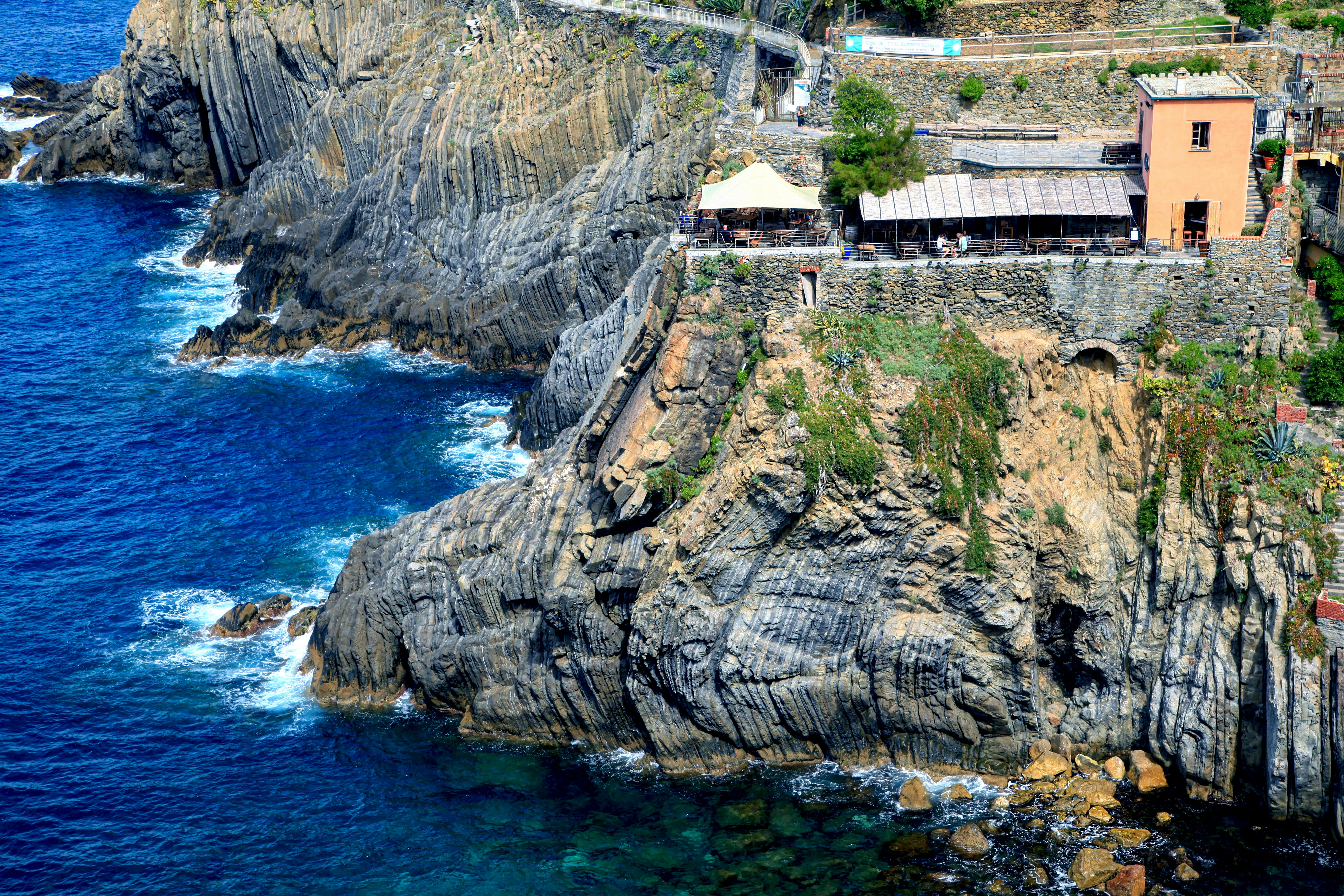 White concrete building on cliff near body of water during daytime ...