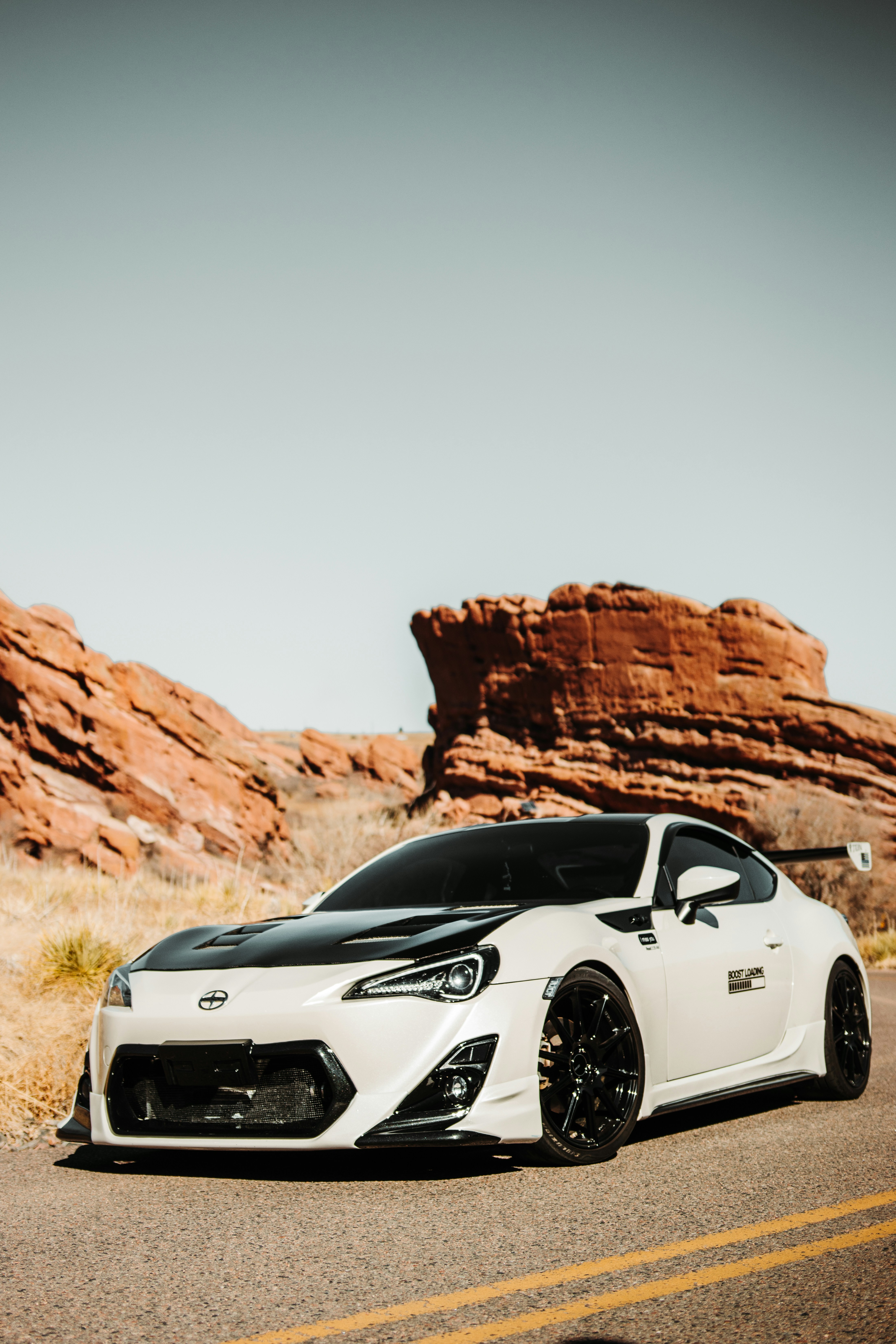 Desert Sprint: White sports coupe on a sunlit canyon highway