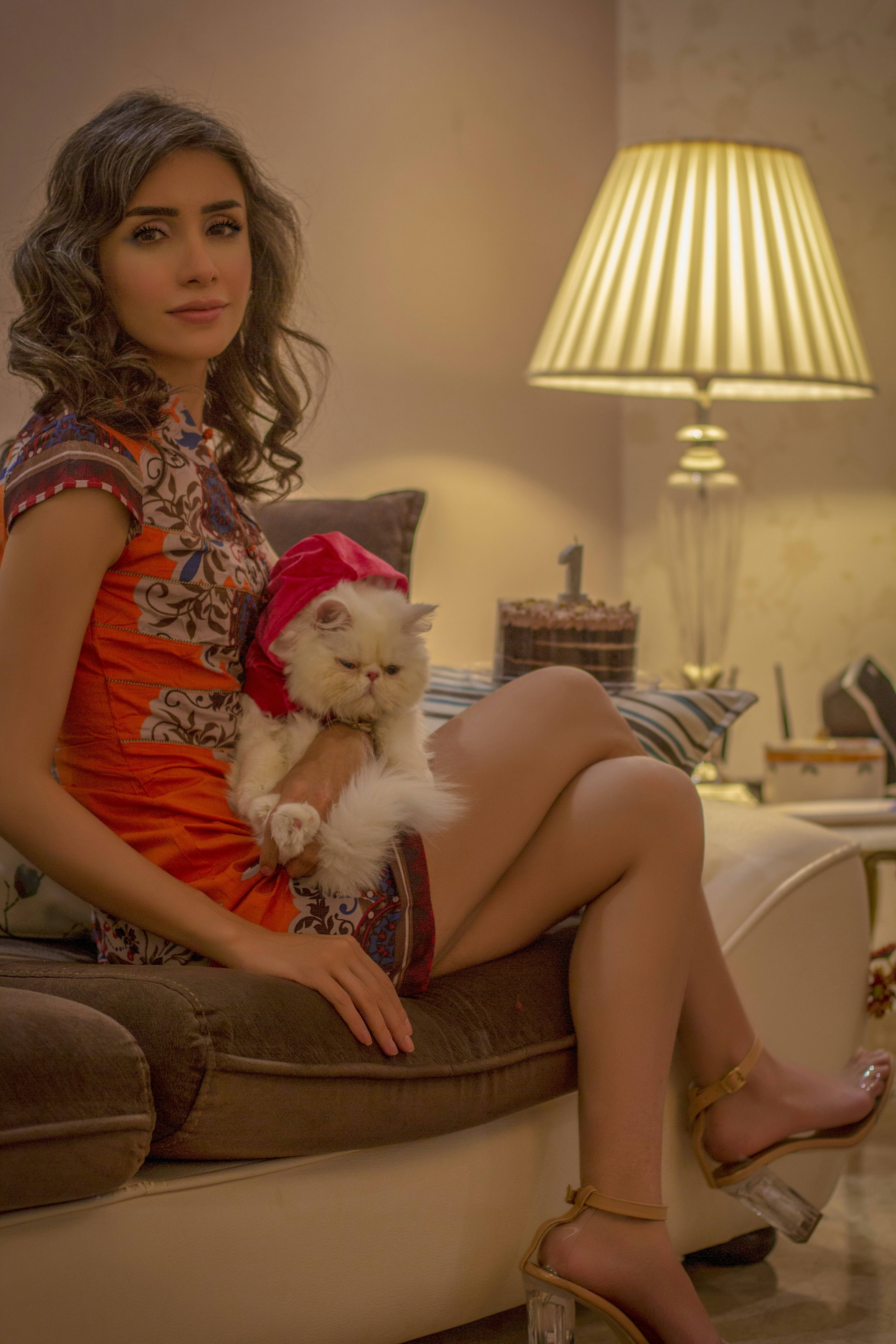 woman in red and white floral dress sitting on brown armchair
