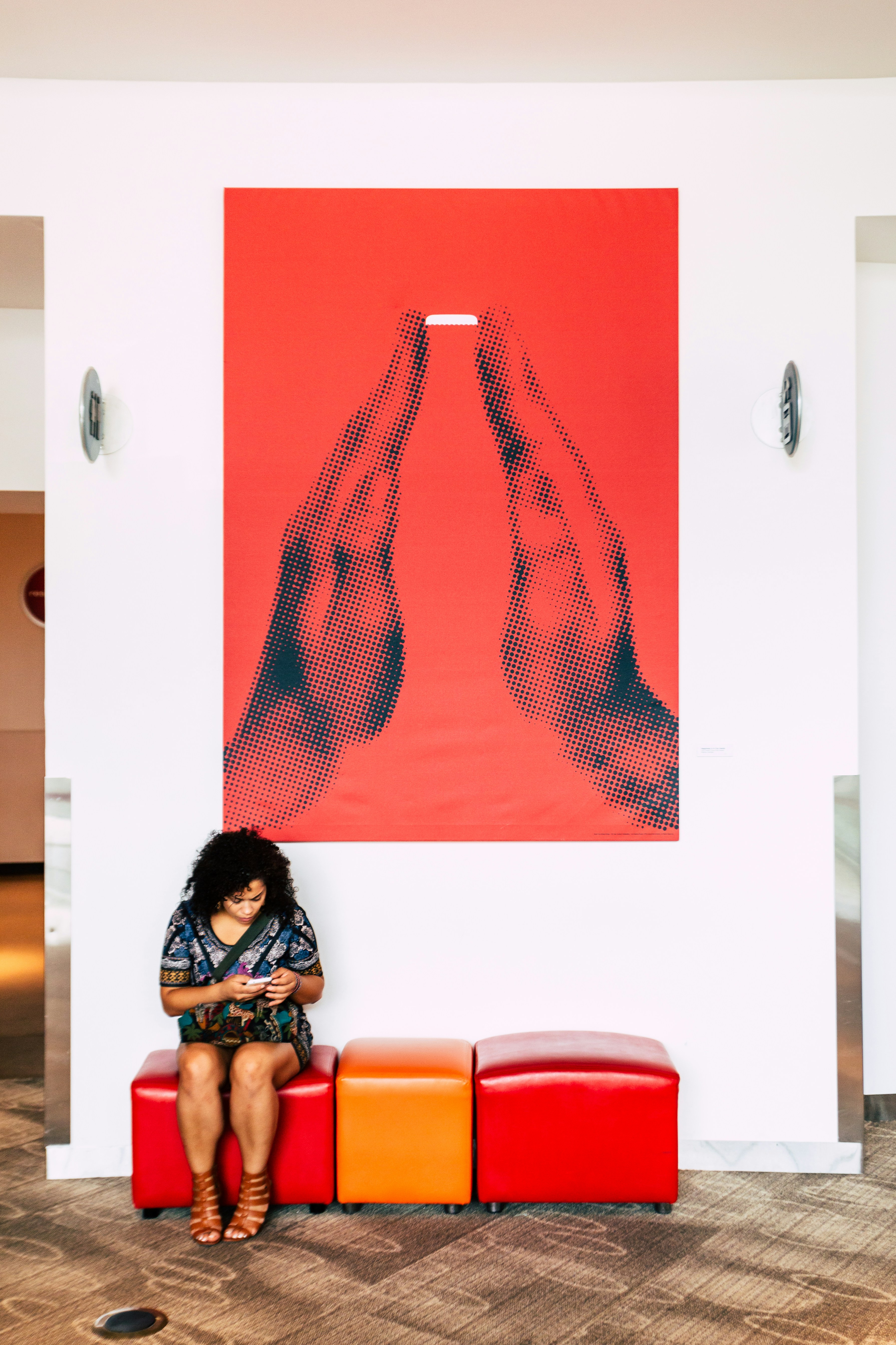 Crimson Hands: A Quiet Moment Under Bold Wall Art