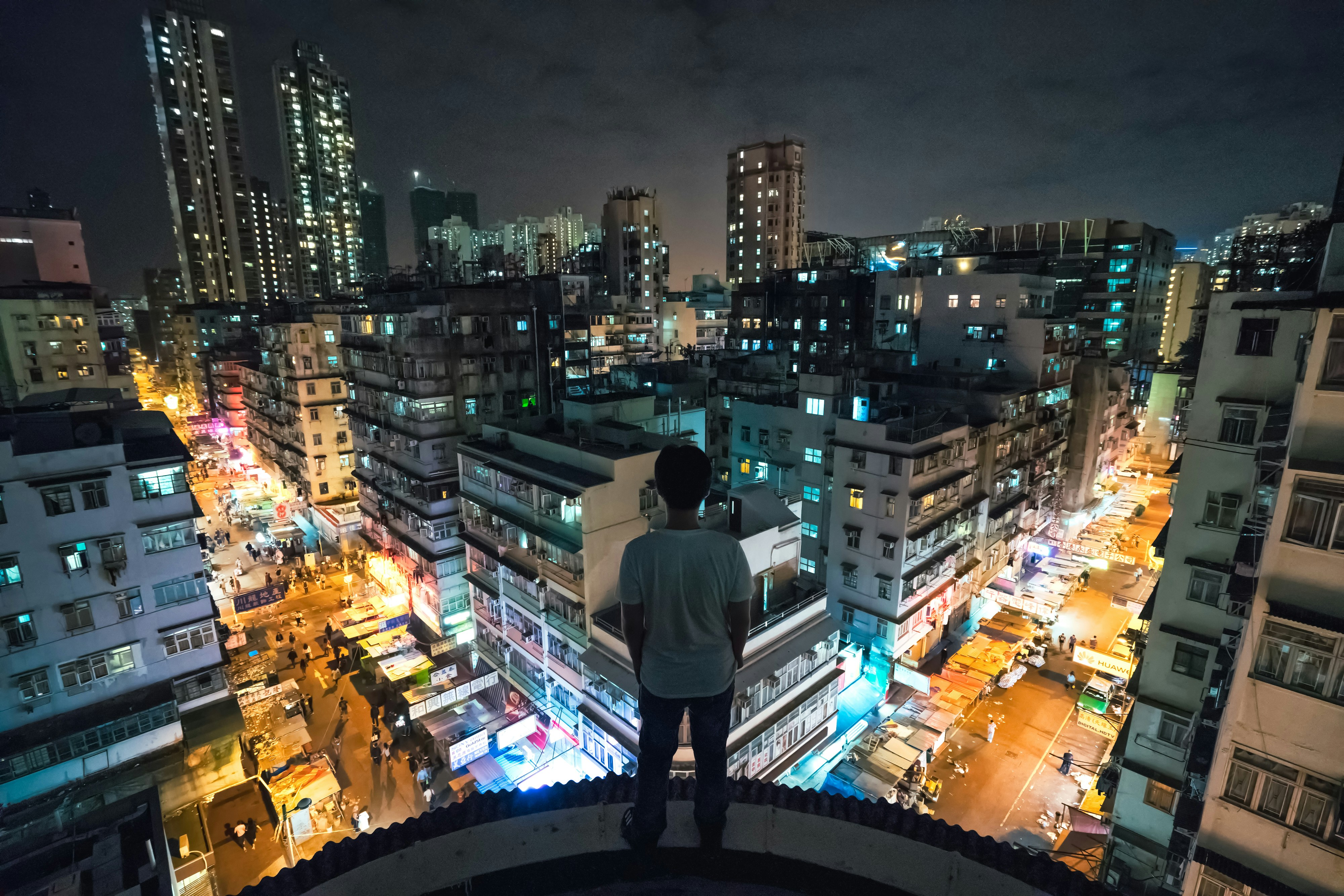 Man in gray shirt standing on top of building during night time photo ...