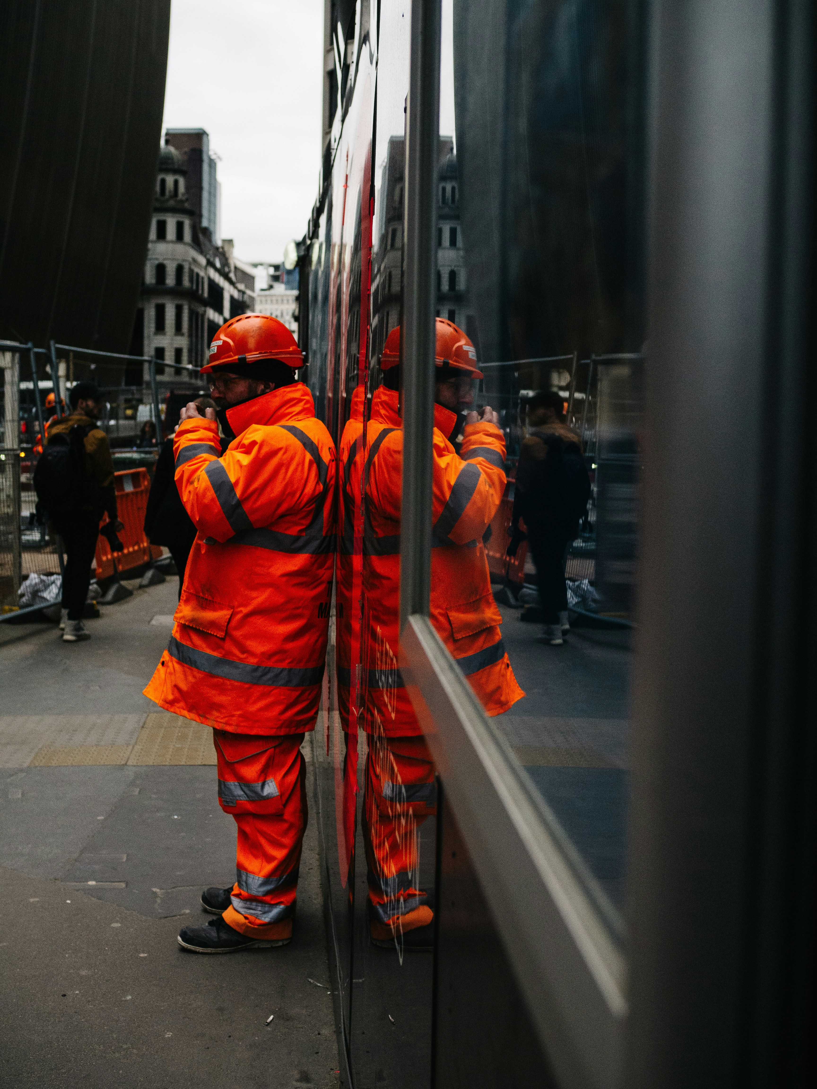 Reflections in Orange: Construction Worker and City Glass