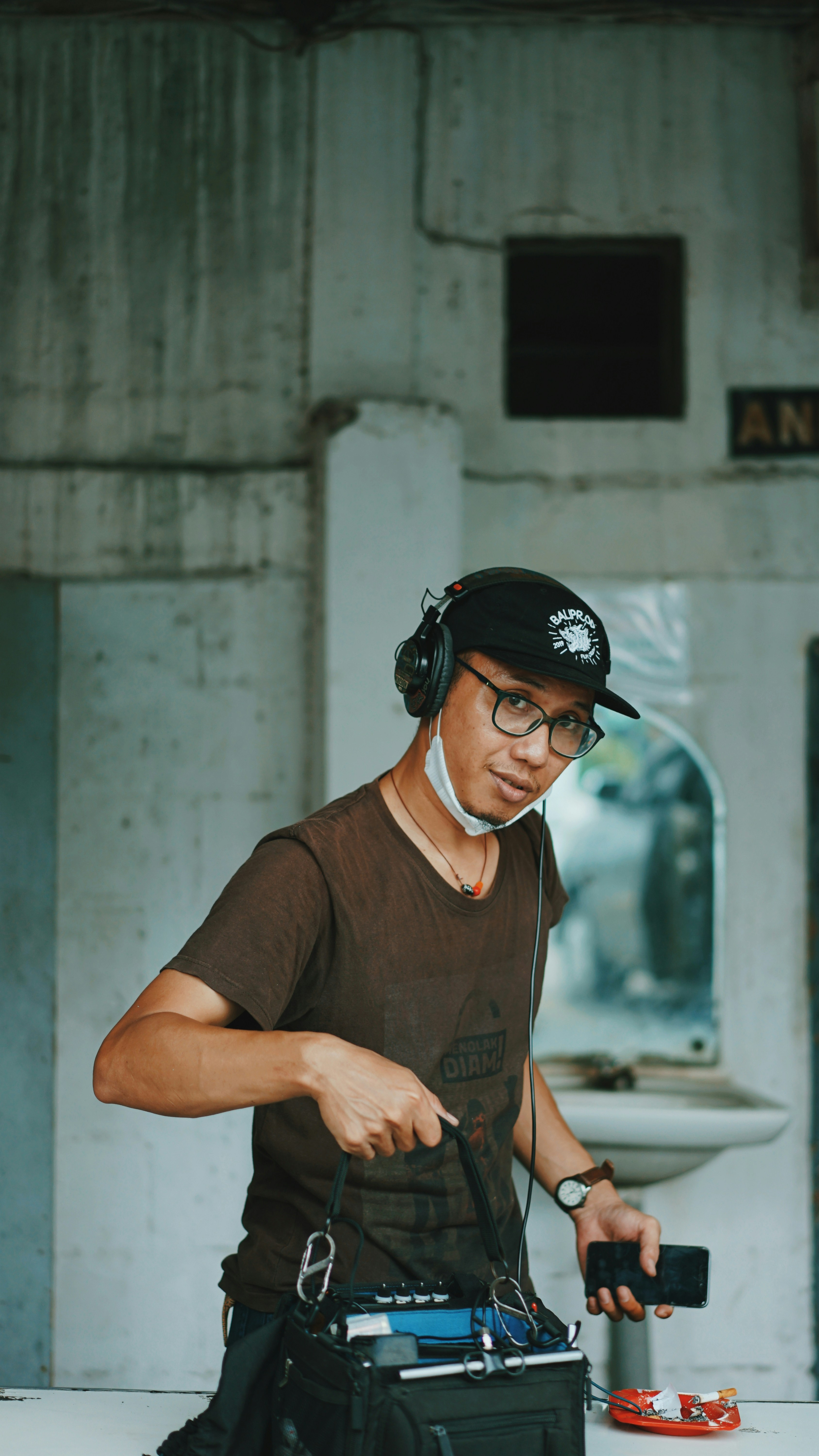 Man in brown crew neck t-shirt wearing black cap and black sunglasses ...