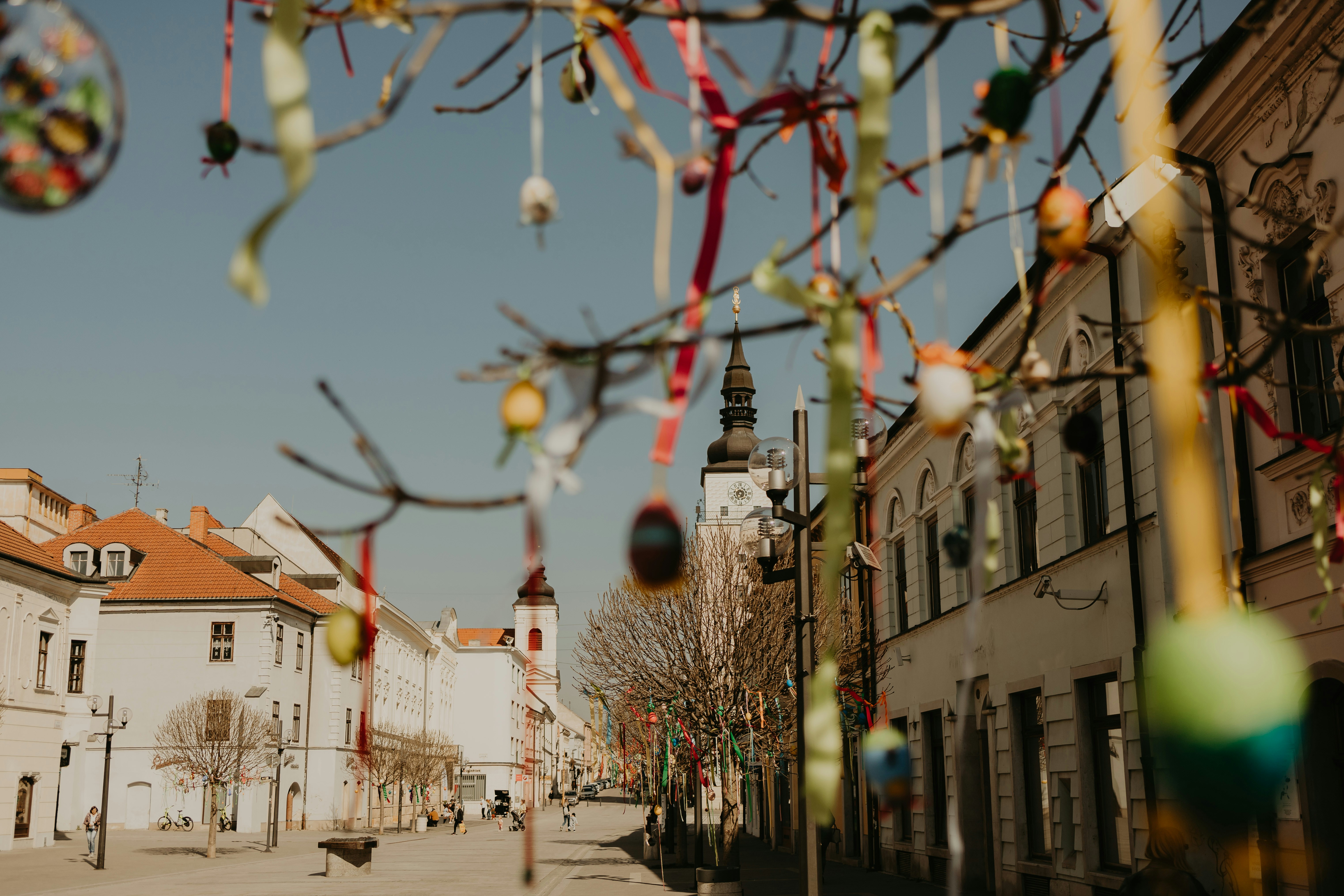 Festooned Frame: A Town Clocktower Emerges Through Colorful Garlands