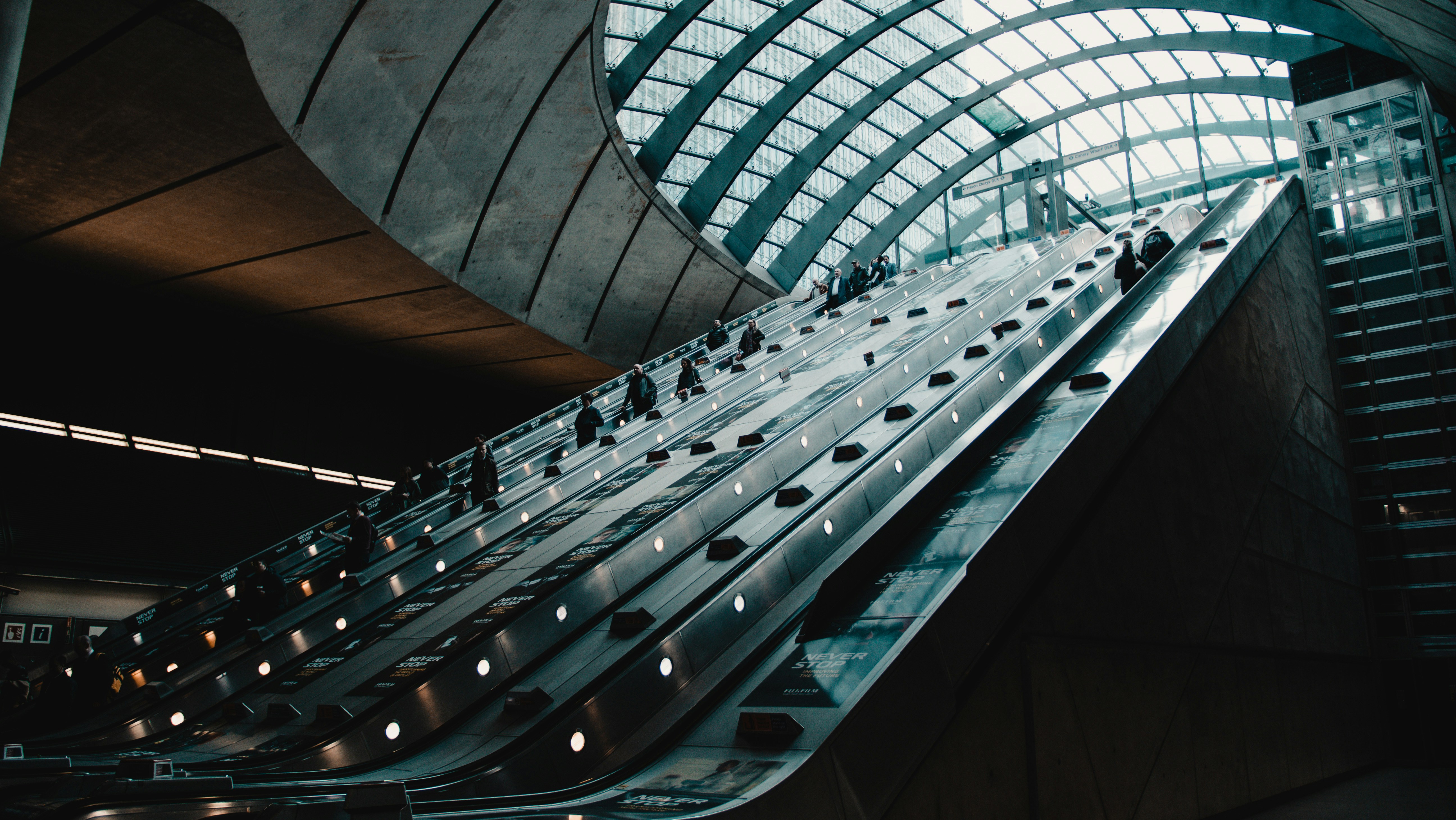 Glass Cathedral Ascent: Escalator Under a Curved Sky