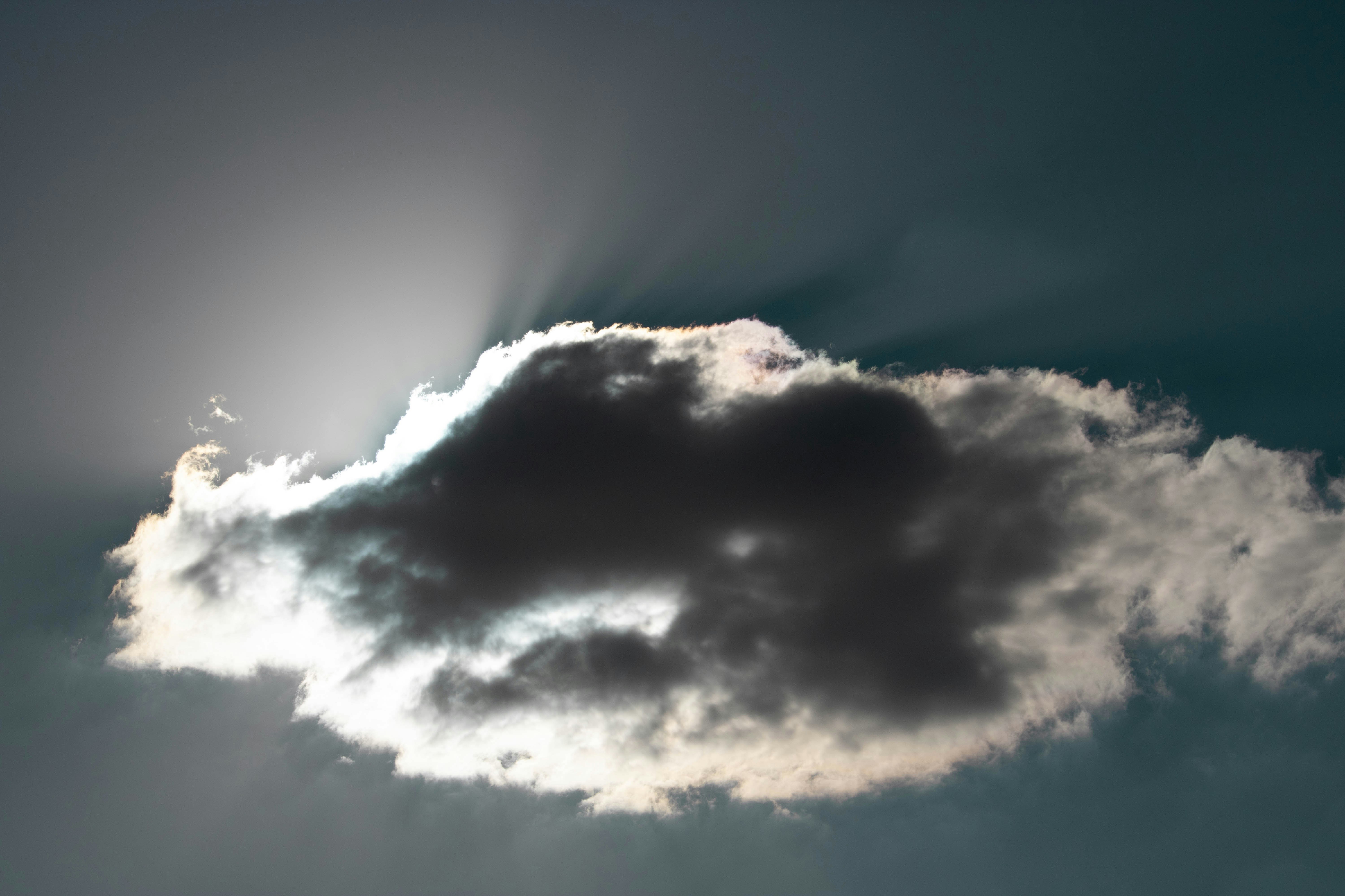 Rim-Lit Cloud Crest: A Quiet Sunburst Behind Soft Sky