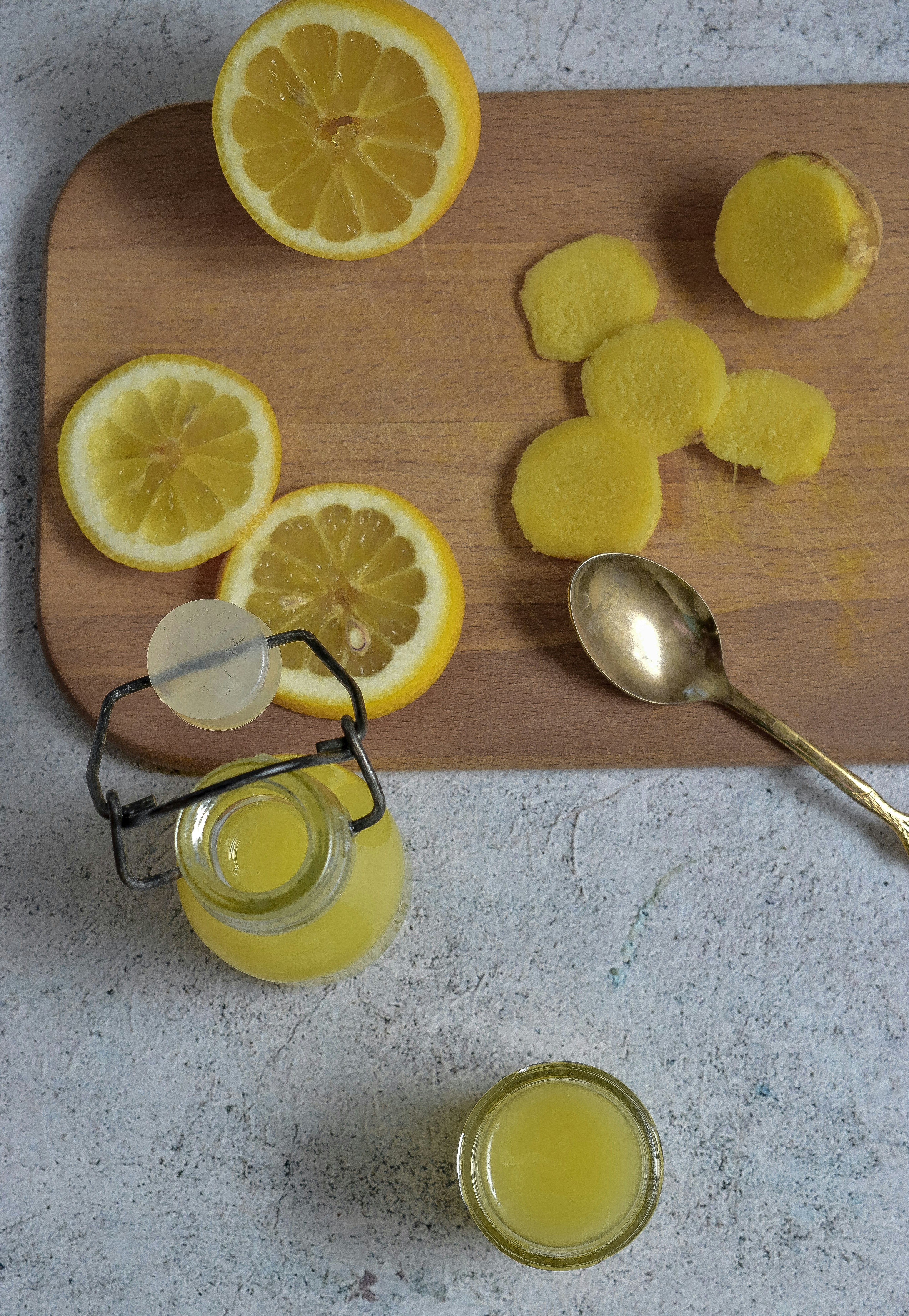 a wooden cutting board topped with sliced lemons and a glass of juice