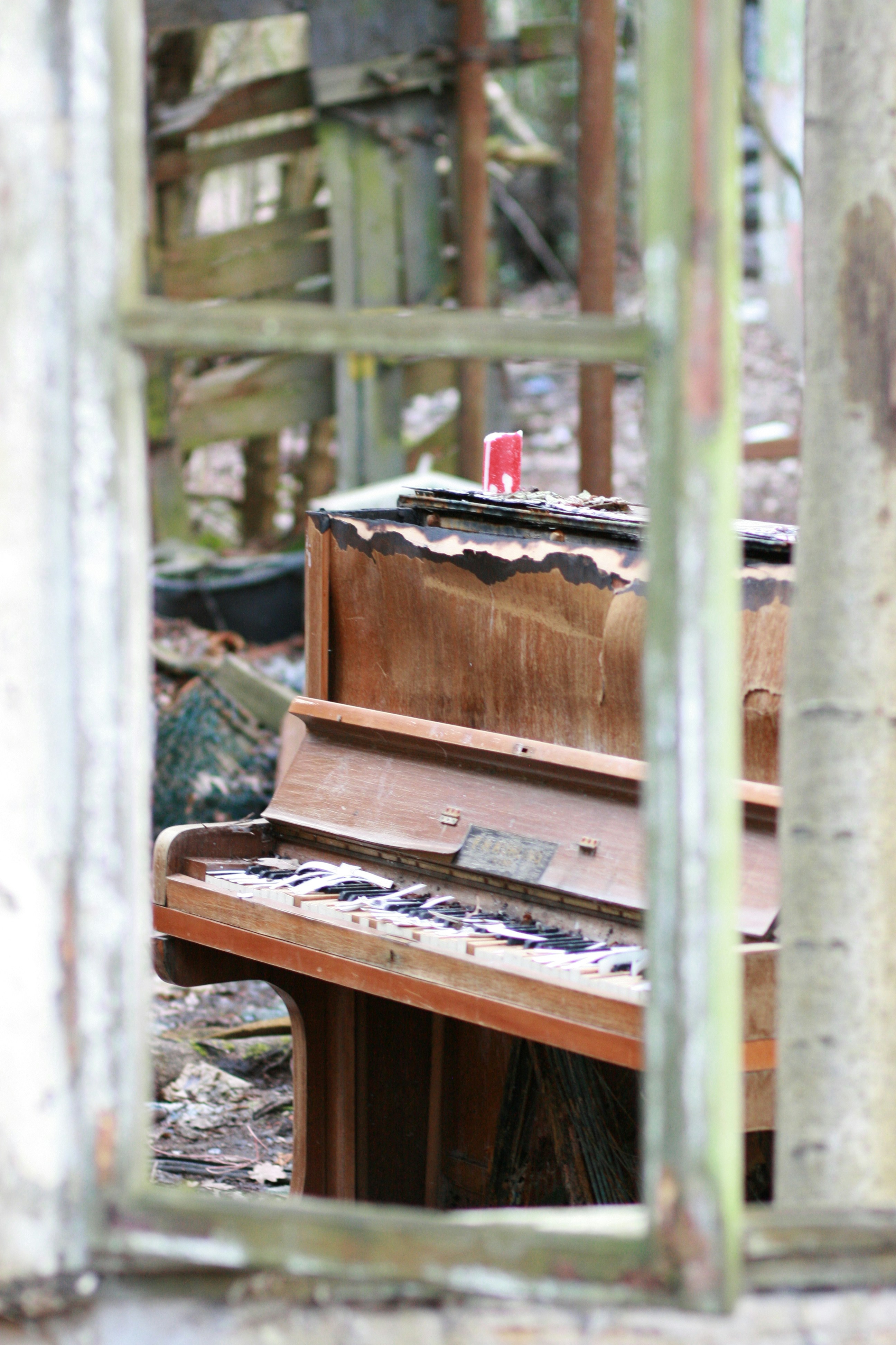 brown upright piano with red and white book on top