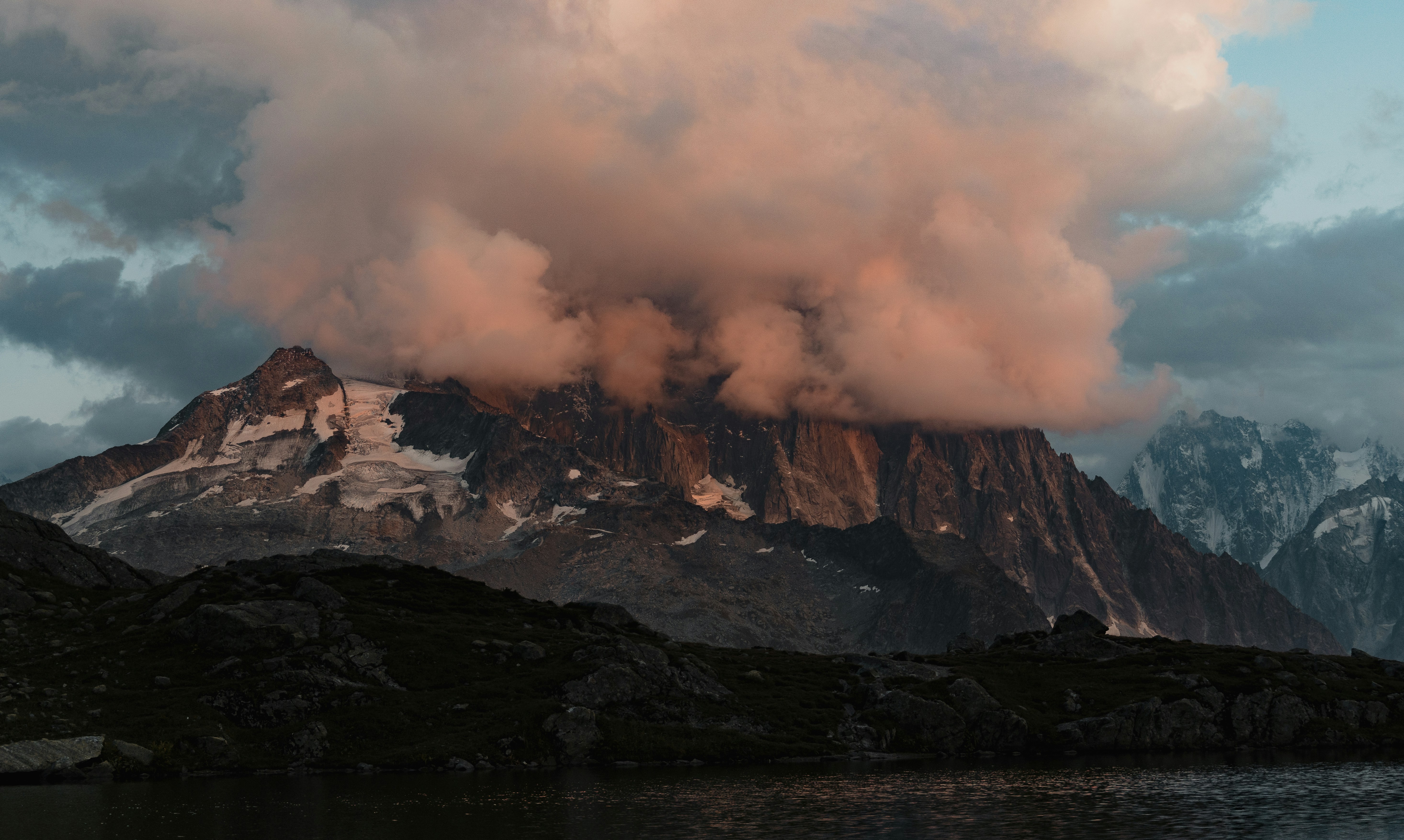 Cloud-wreathed peak: twilight over a rugged alpine shore