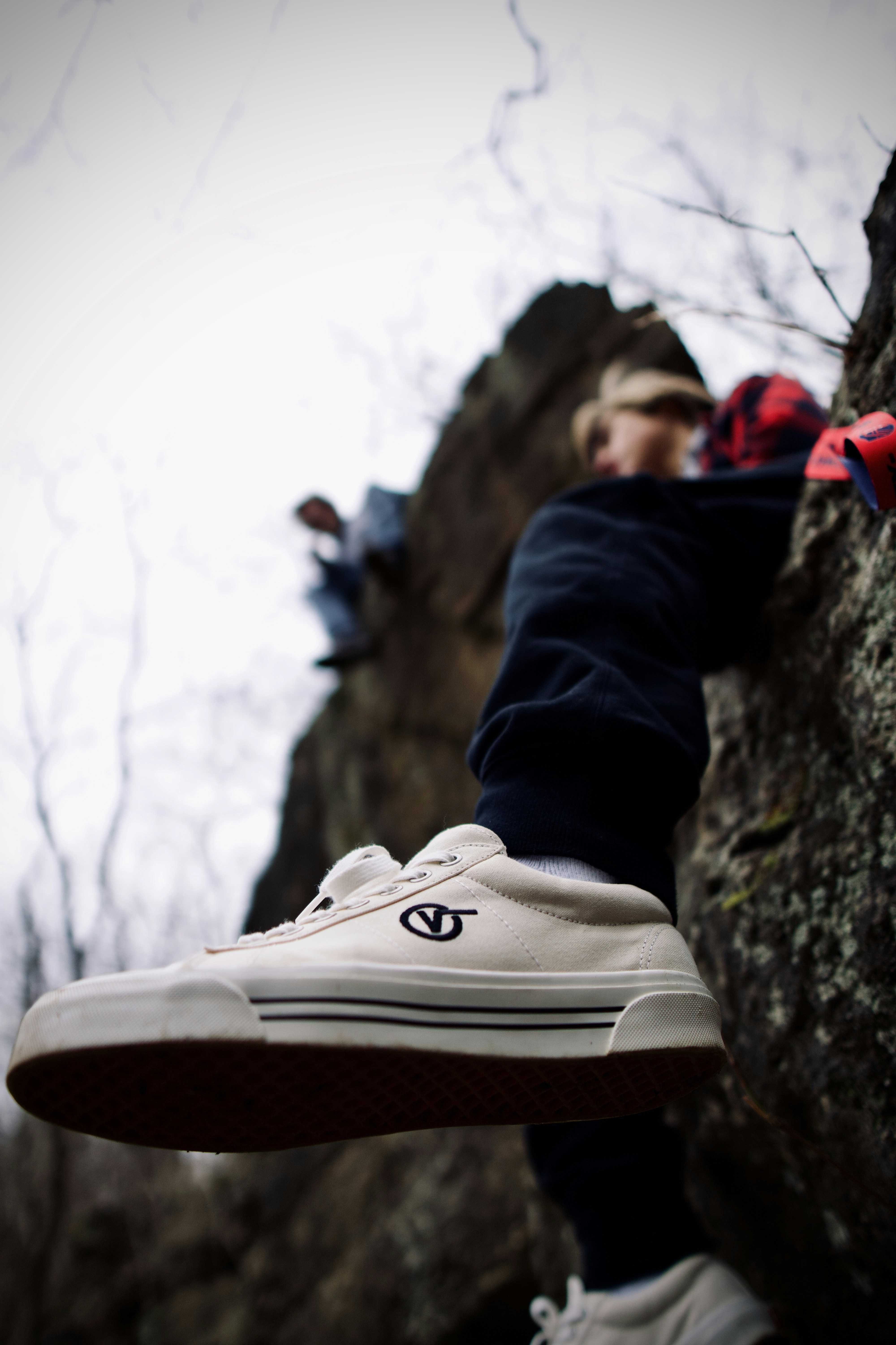 Grip and Grit: Close-Up of a Climber's White Sneaker Anchoring the Route