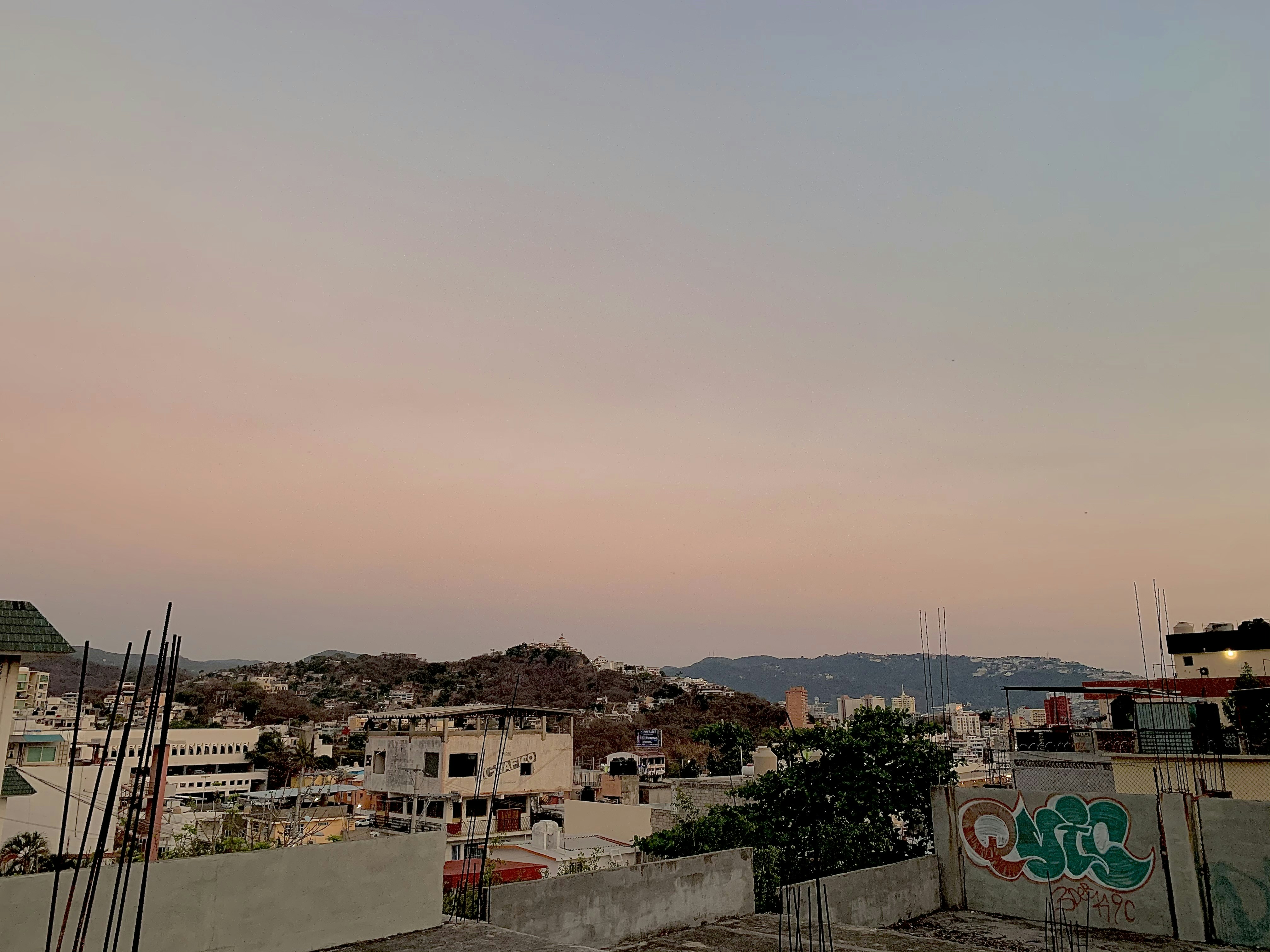 6:58 pm  | white and red concrete building near green trees during daytime