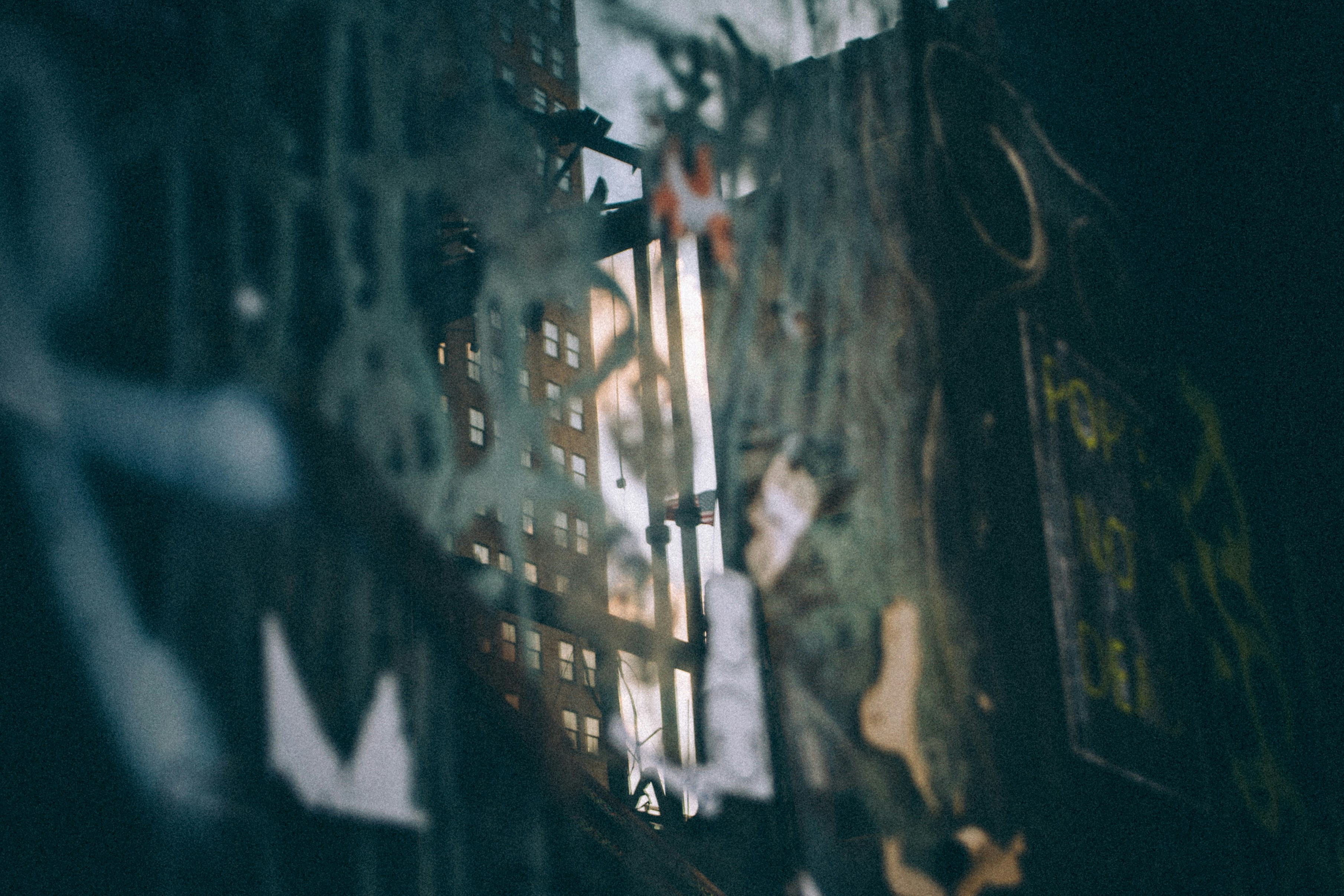 Layered textures of graffiti and urban decay juxtaposed with reflections of towering buildings. 