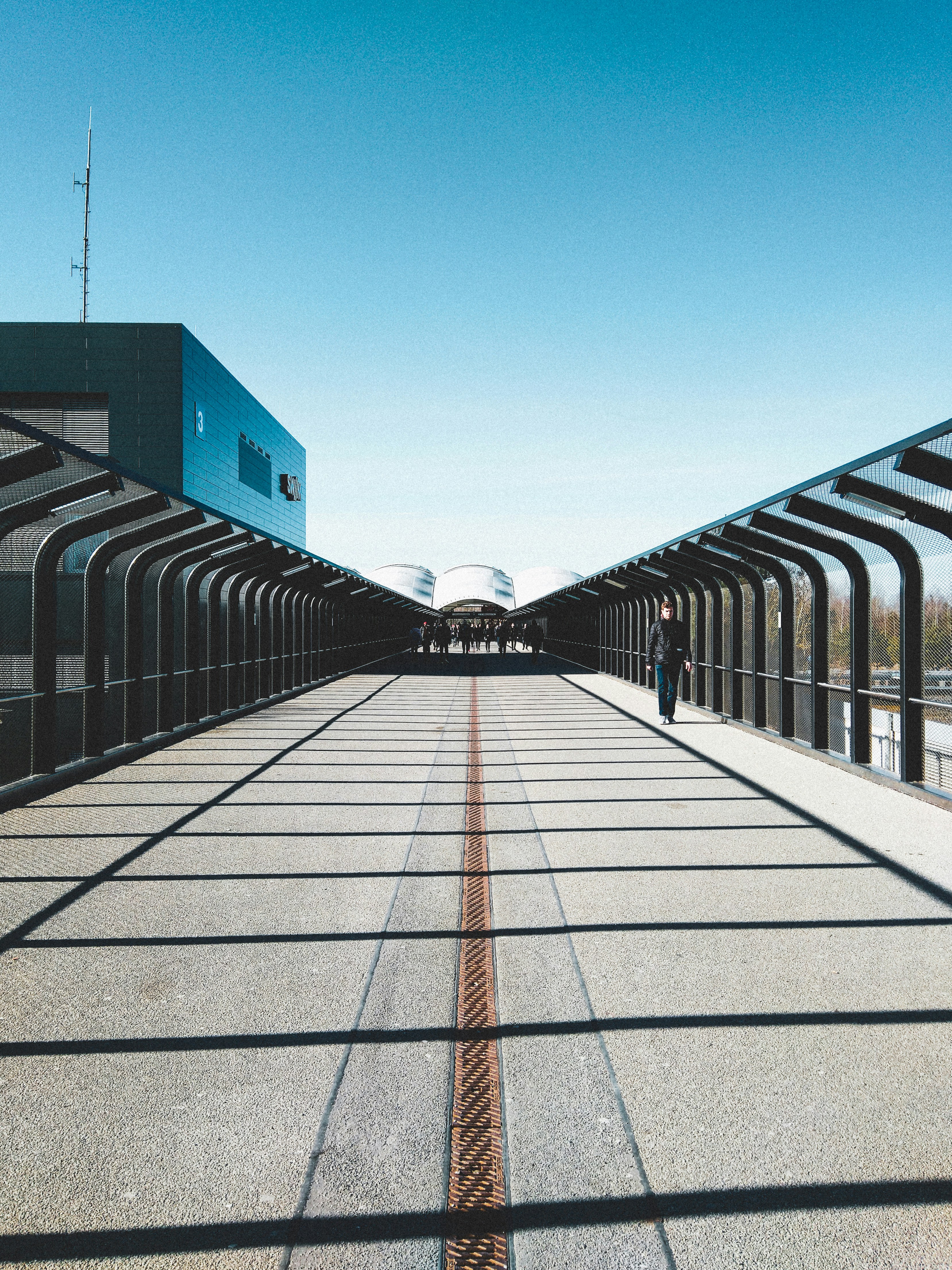Gray concrete pathway between blue and red building during daytime ...